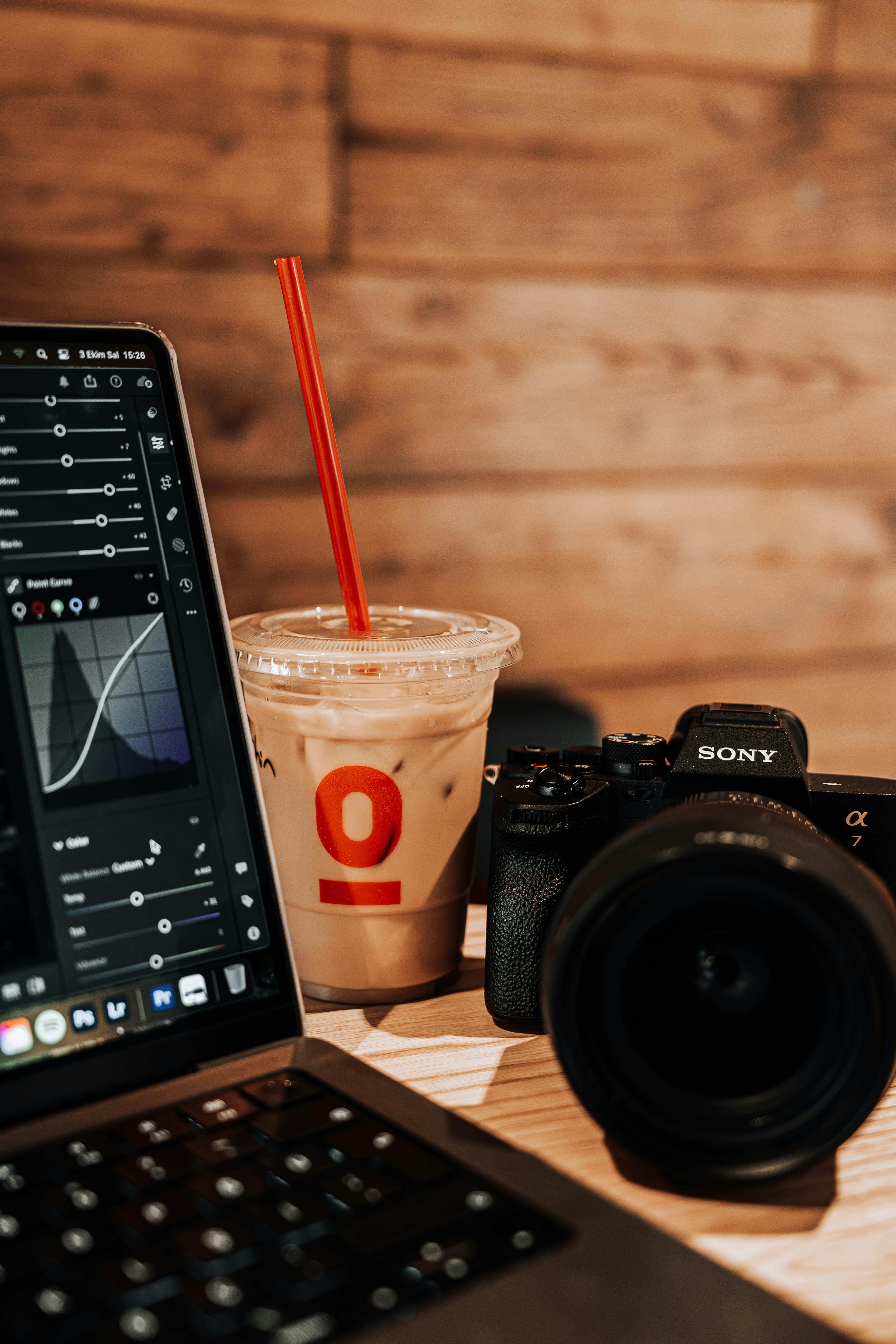 A Laptop, Camera and Iced Coffee Standing on the Table · Free Stock Photo