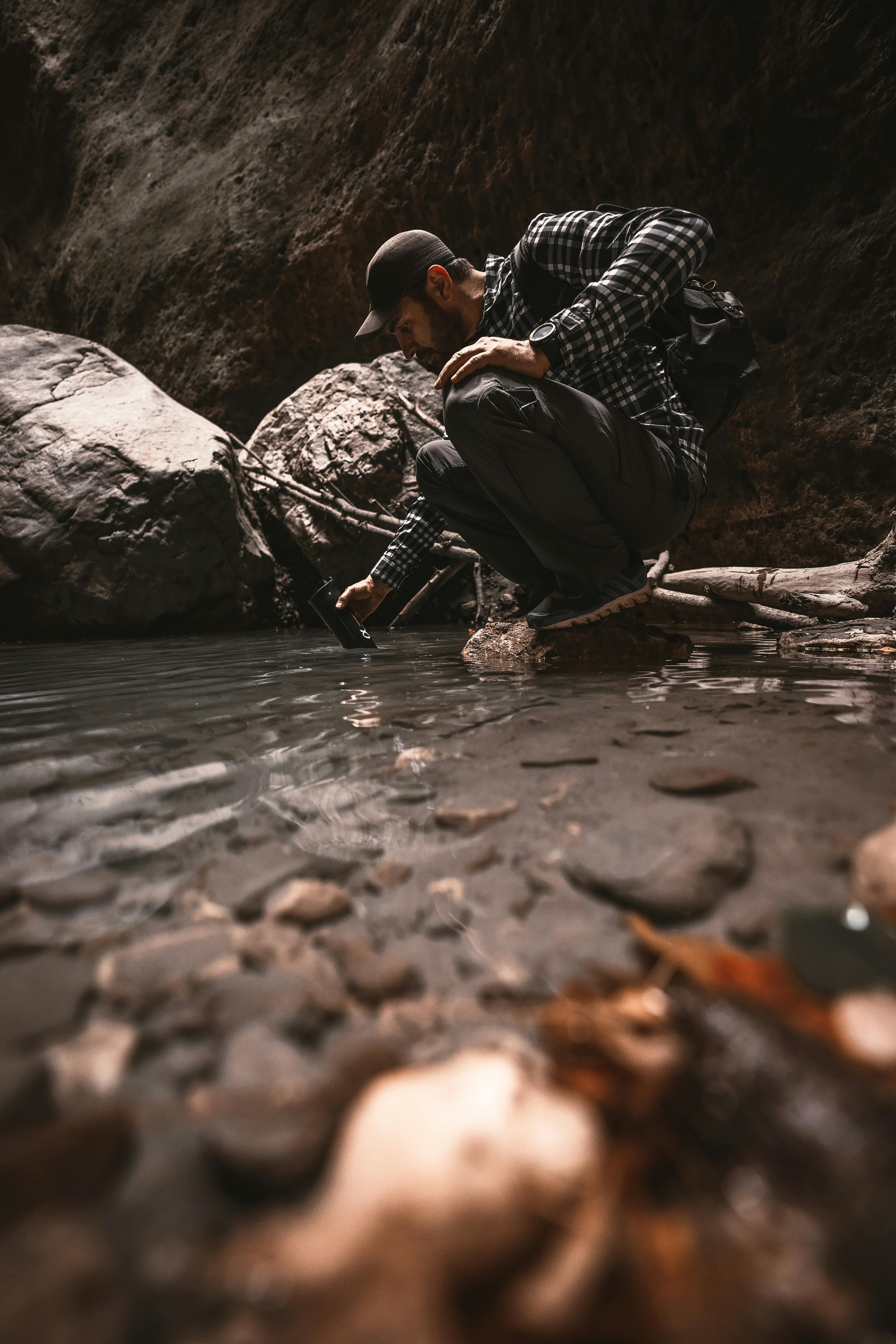 Man Taking Water into an Outdoor Water Purifier · Free Stock Photo