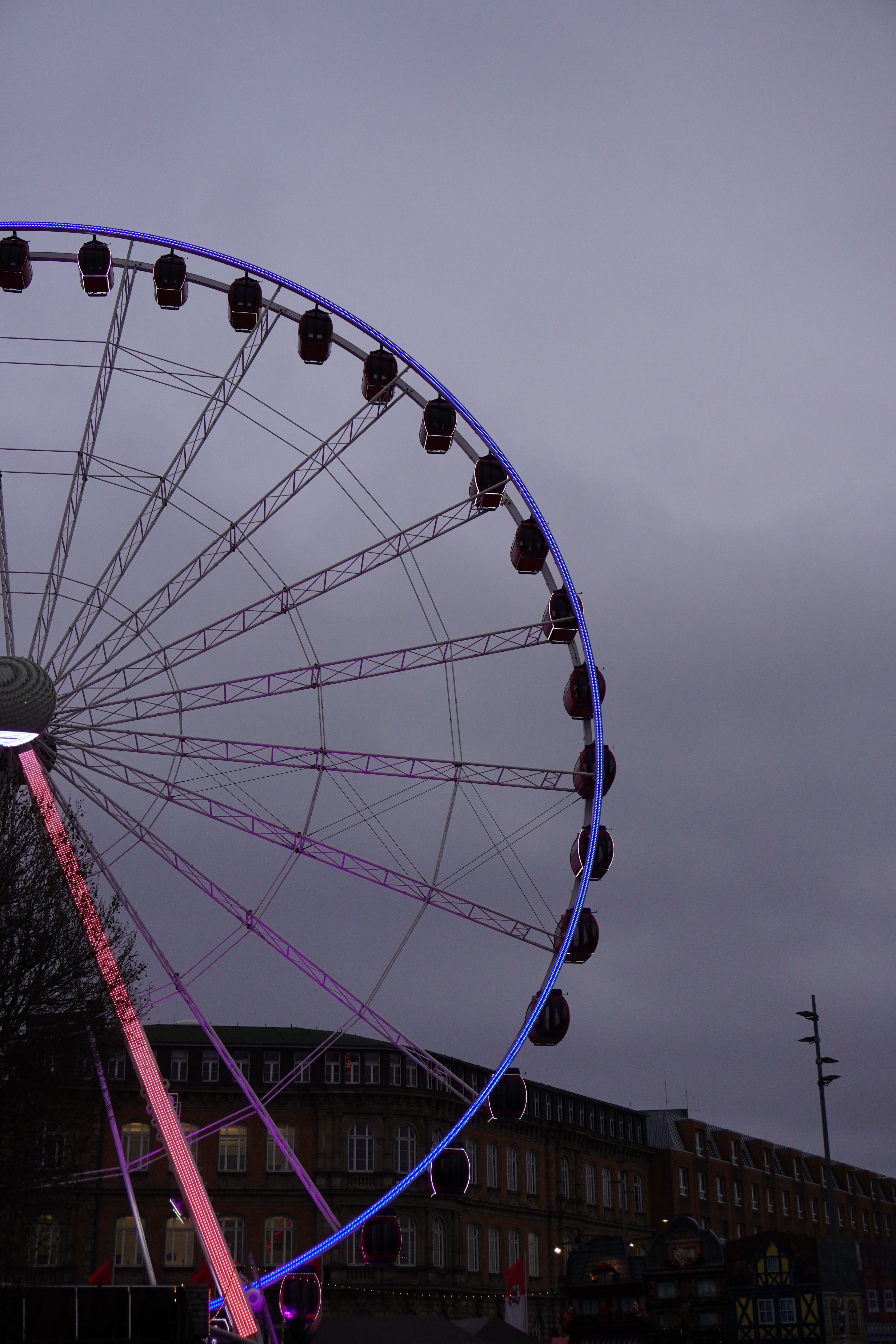 Woman Facing Ferris Wheel While Making Heart Hand Sign · Free Stock Photo