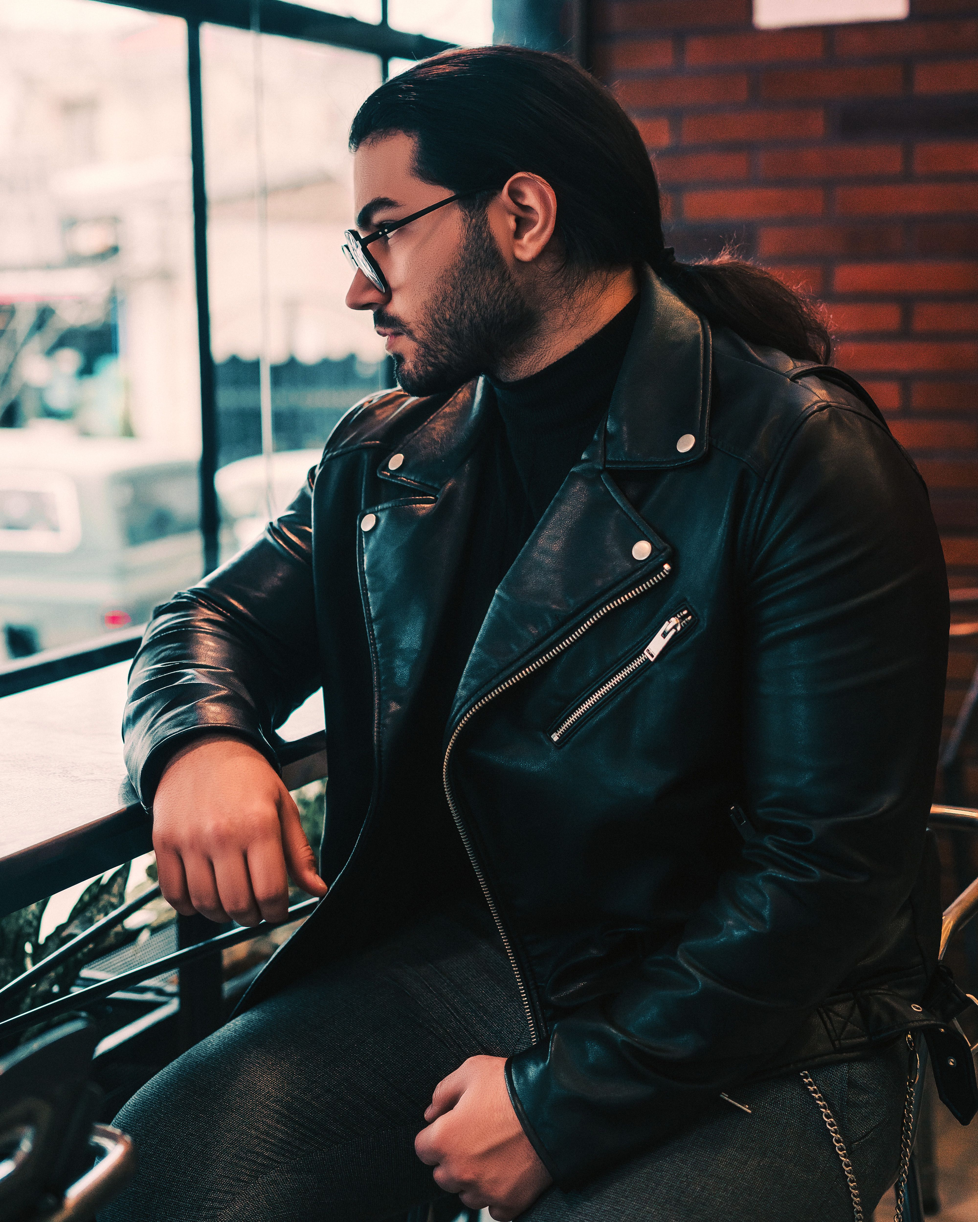 Bearded Man with Long Hair Wearing a Leather Jacket Sitting at the ...