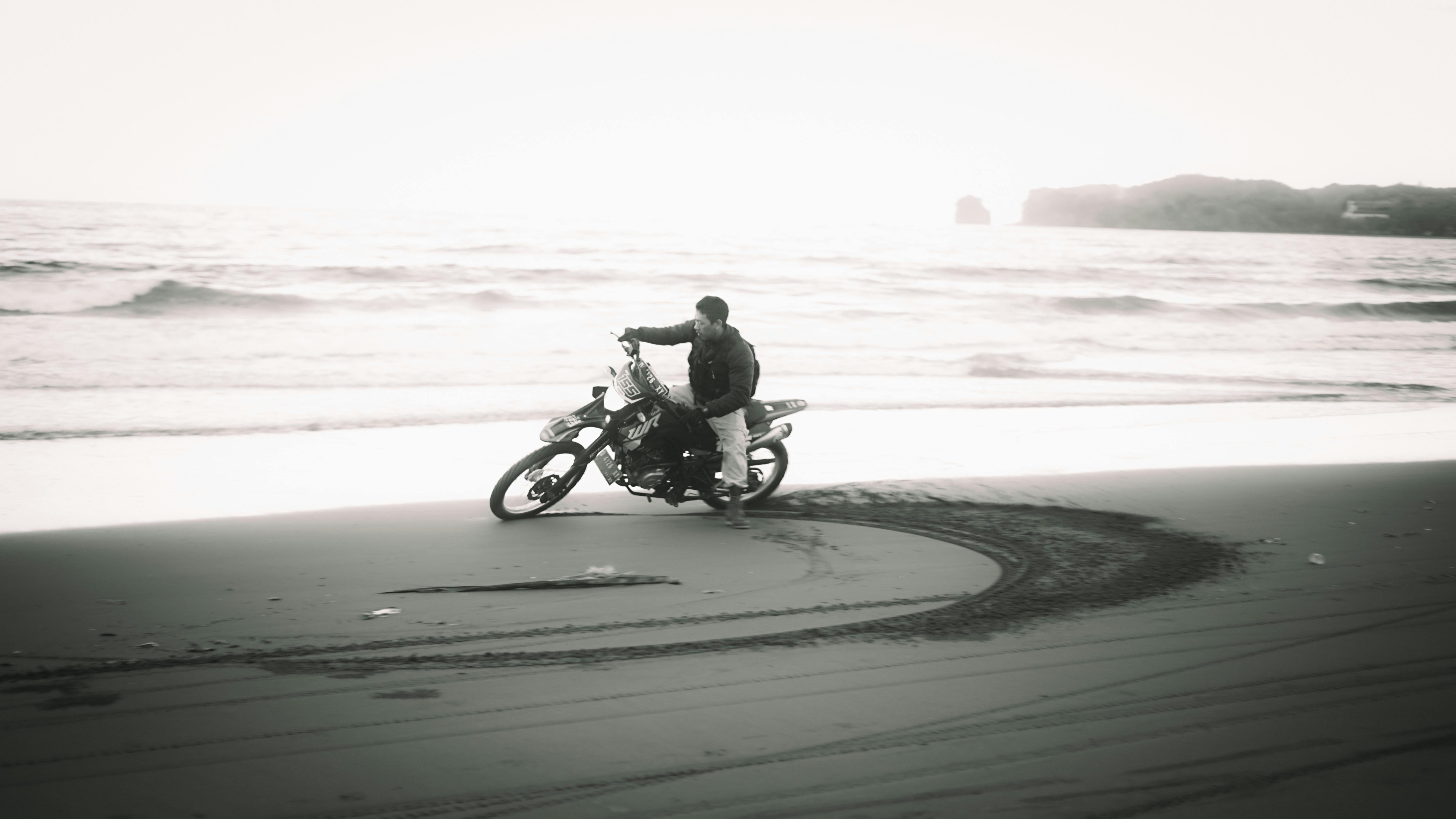 A man riding a motorcycle on the beach · Free Stock Photo