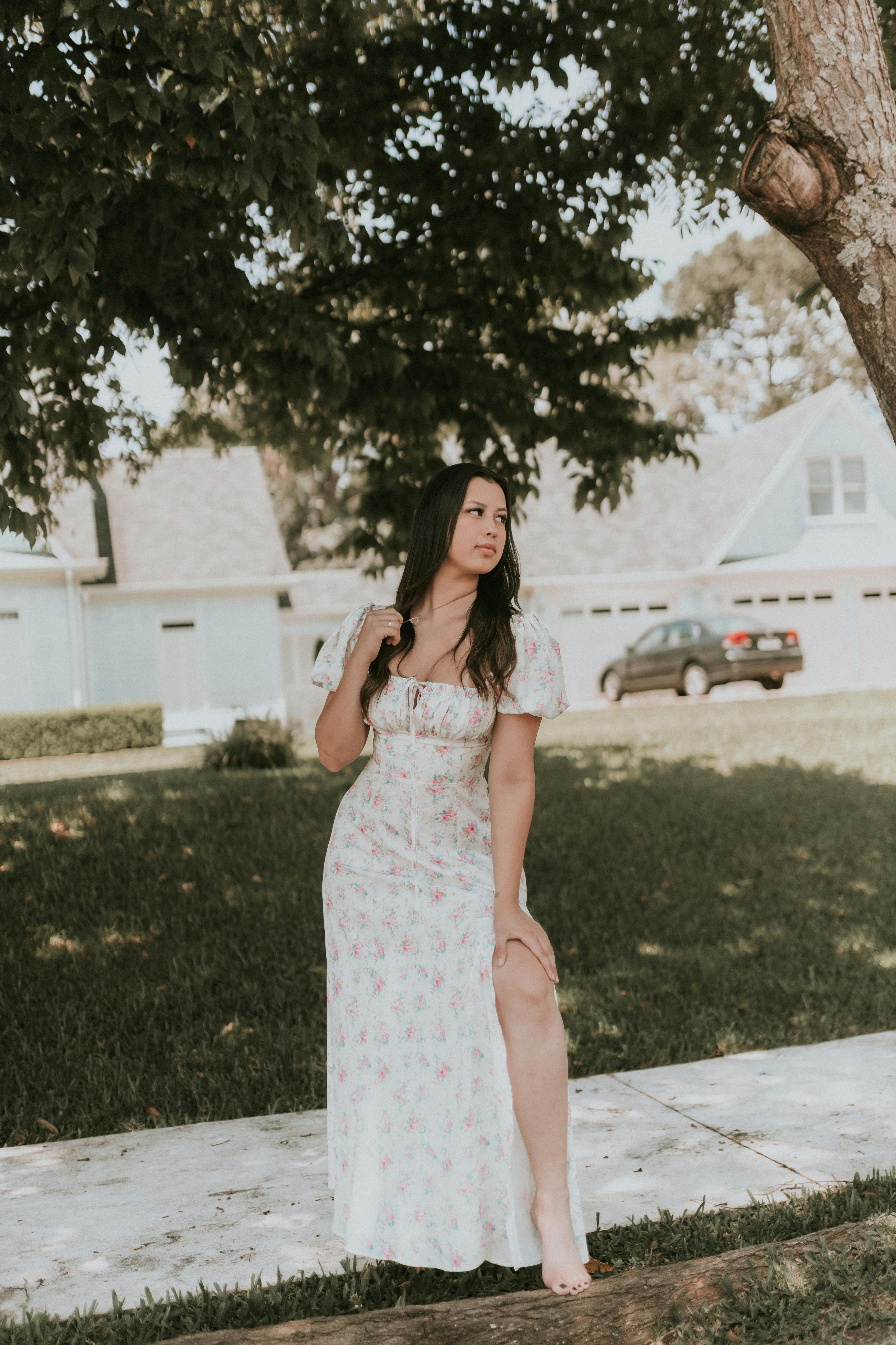 Woman in Floral Sundress Holding Hand on Knee · Free Stock Photo