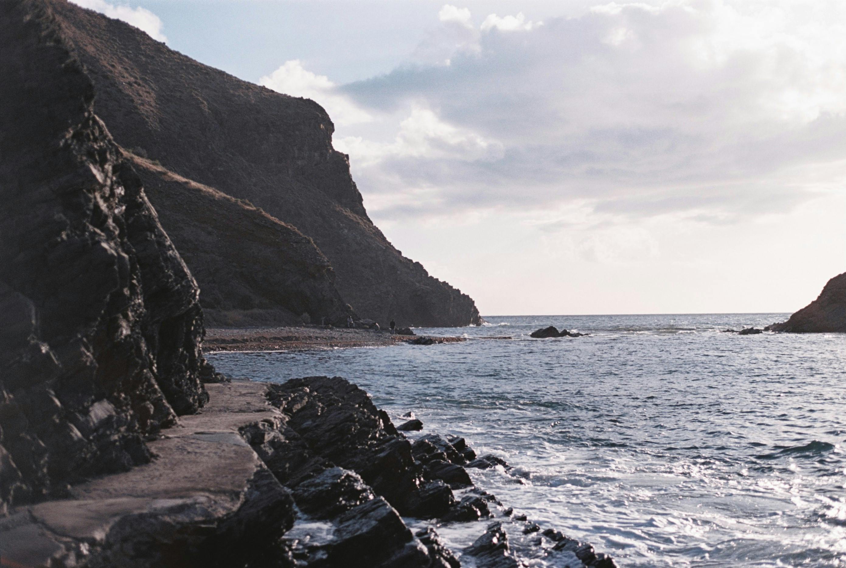 View of a Cliff and Rock Formations on a Shore · Free Stock Photo