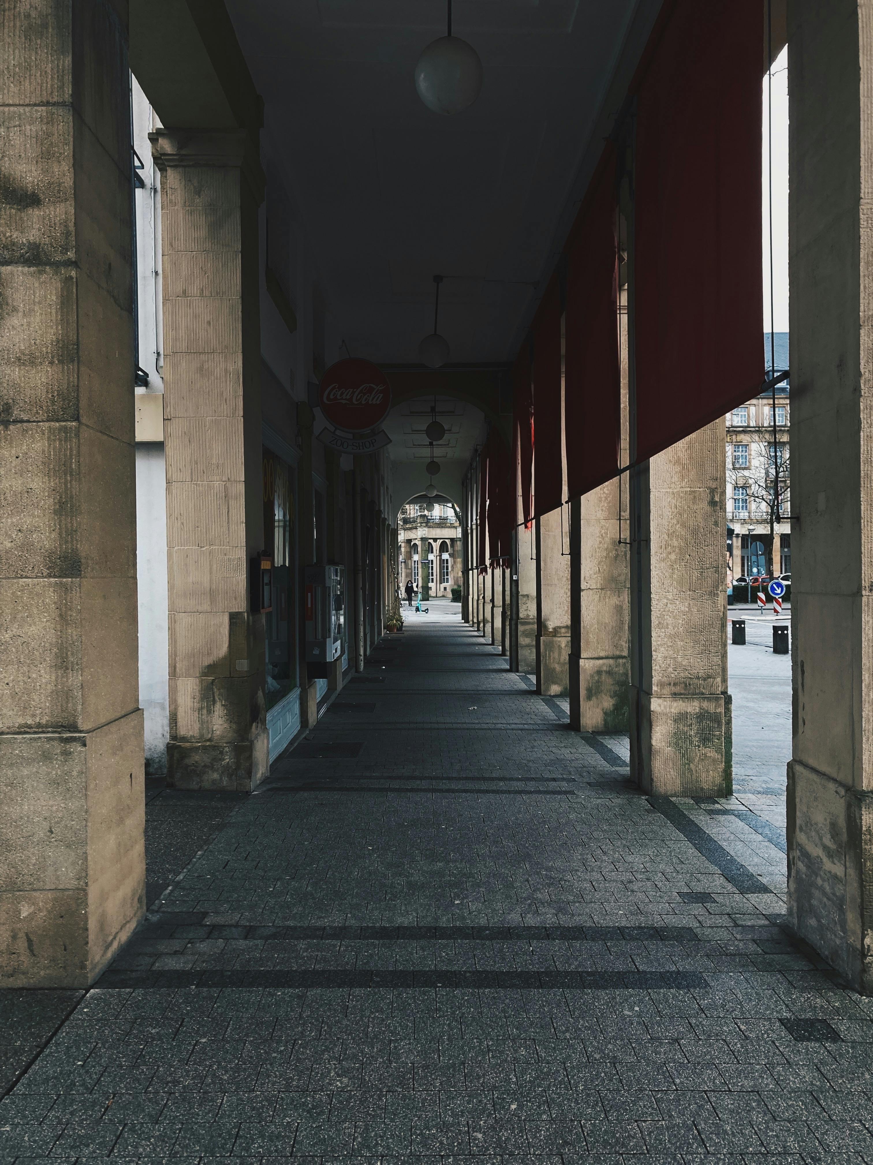 Passage with a Colonnade Decorated with Red Banners · Free Stock Photo