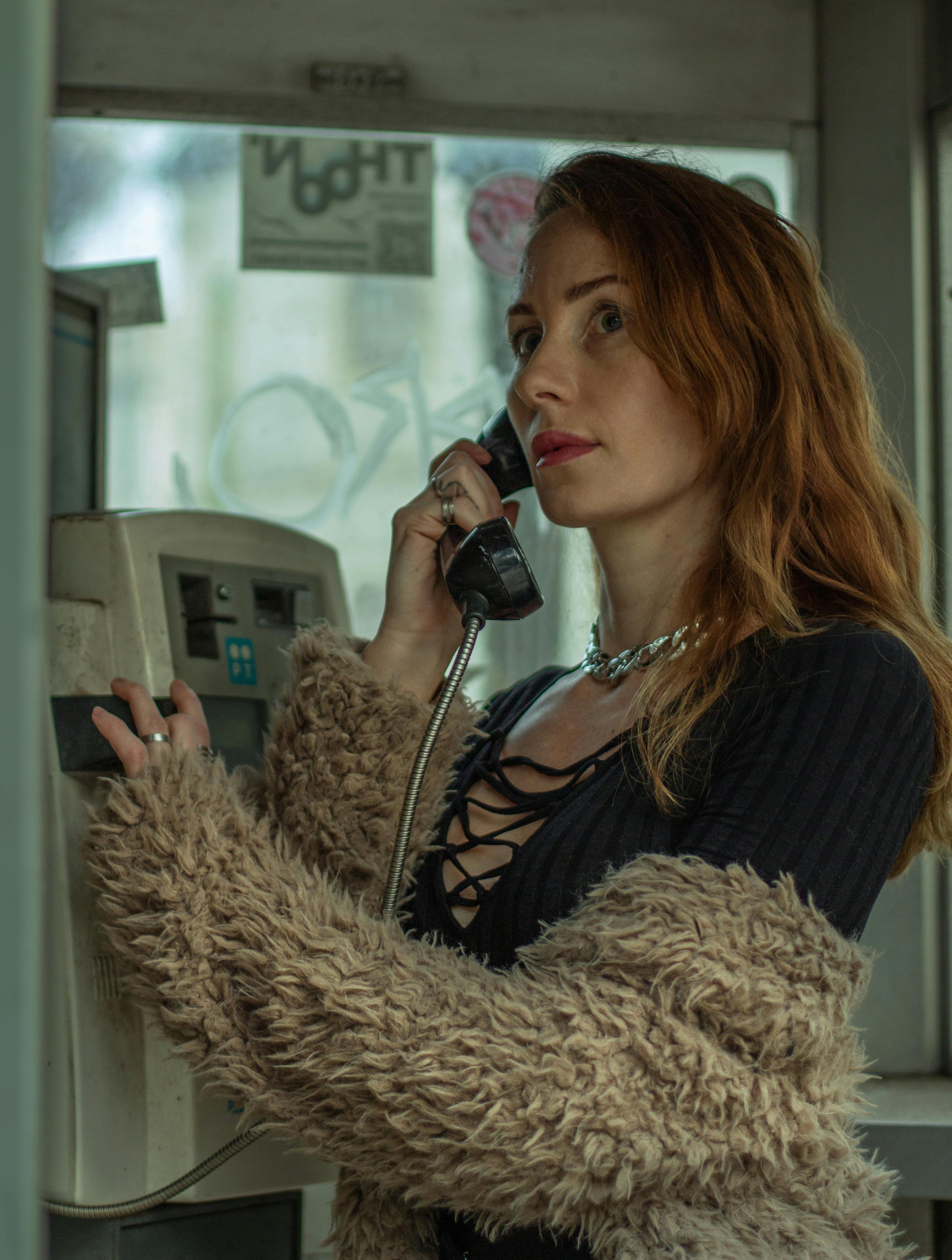 Young Woman Using a Payphone · Free Stock Photo