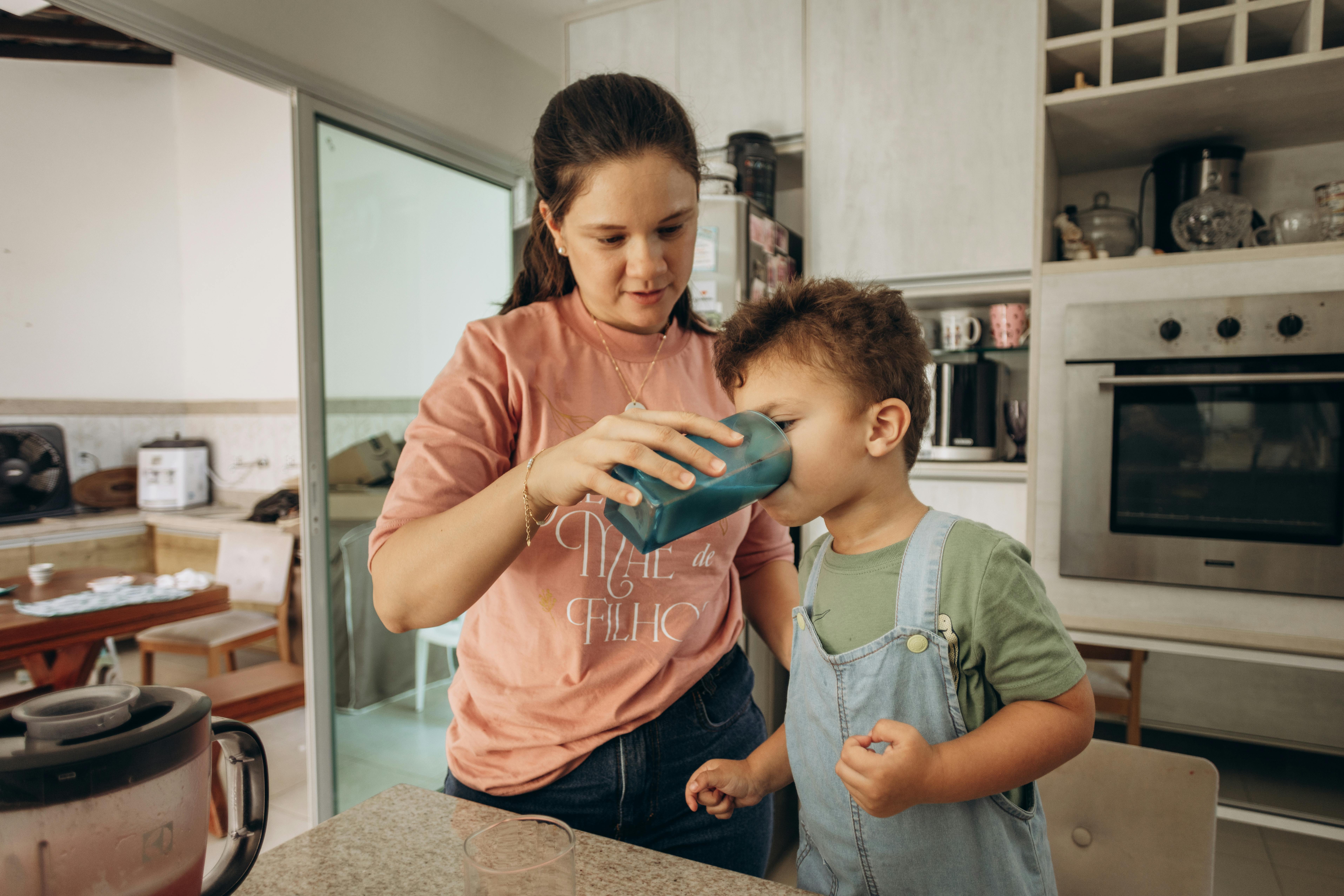 Mother with Son Drinking in Kitchen · Free Stock Photo