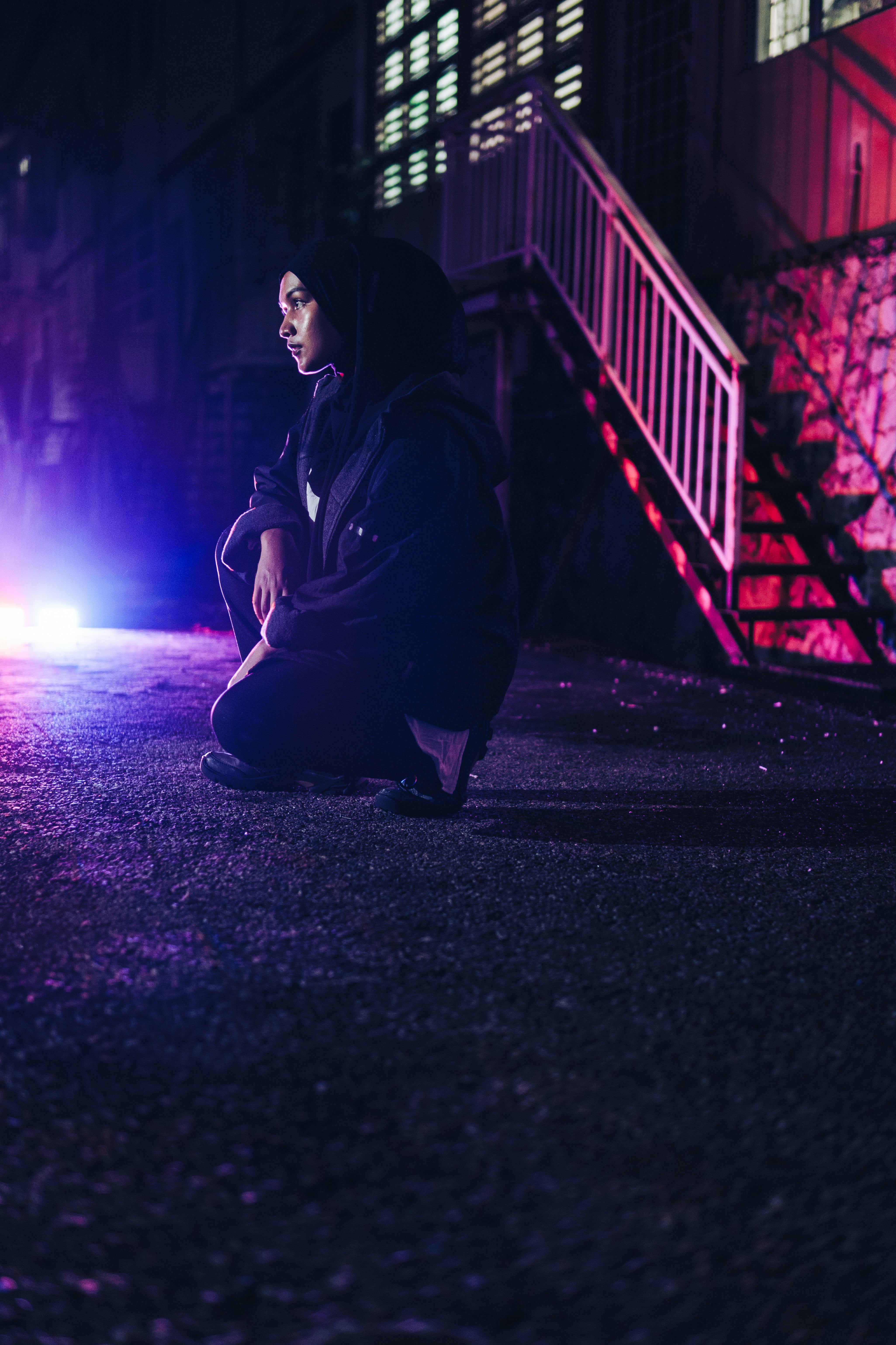 Woman Crouching on Street at Night · Free Stock Photo