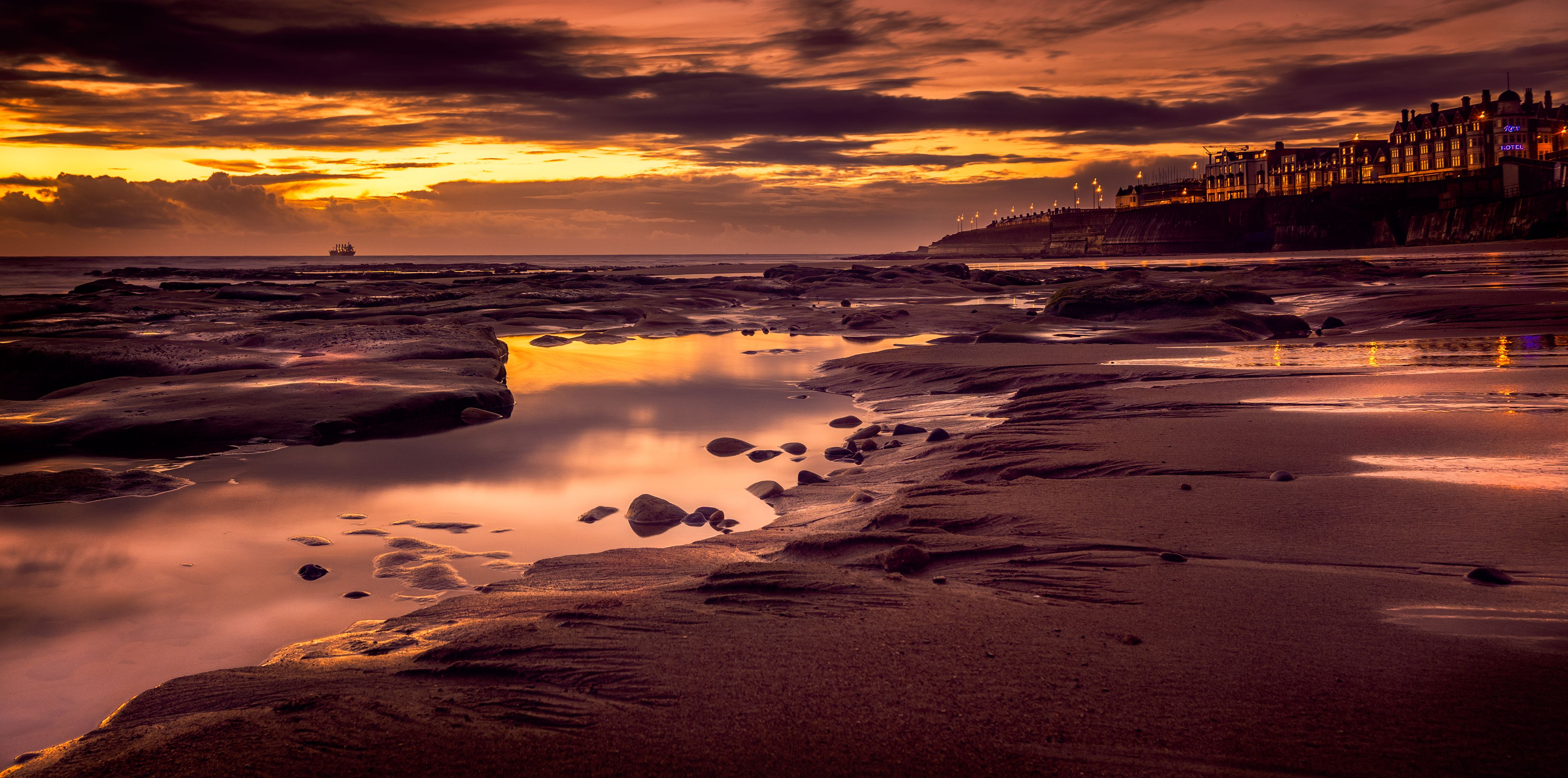 View of the Beach in a Seaside Town at Sunset · Free Stock Photo