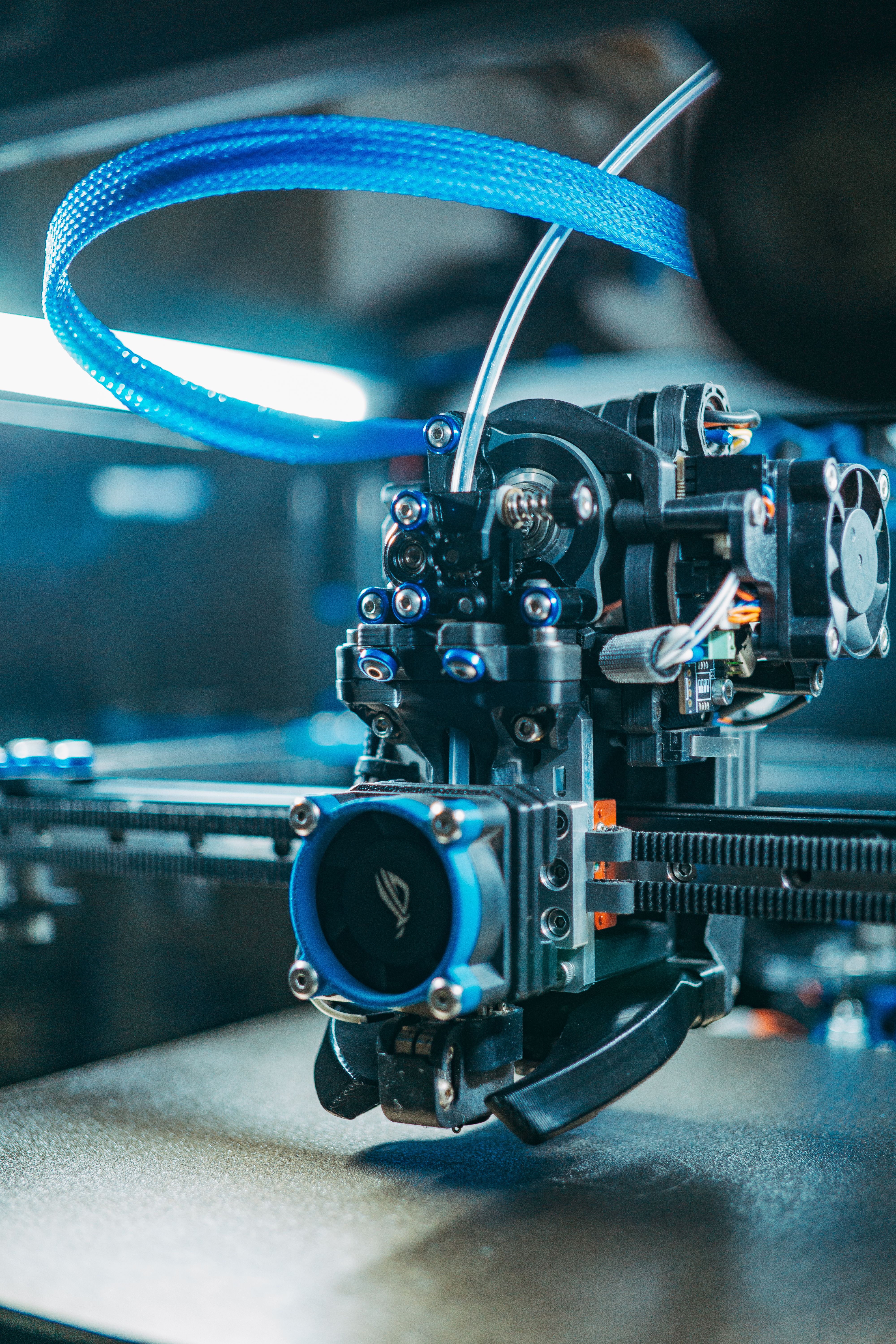 A 3d printer with blue tubing and a blue light · Free Stock Photo