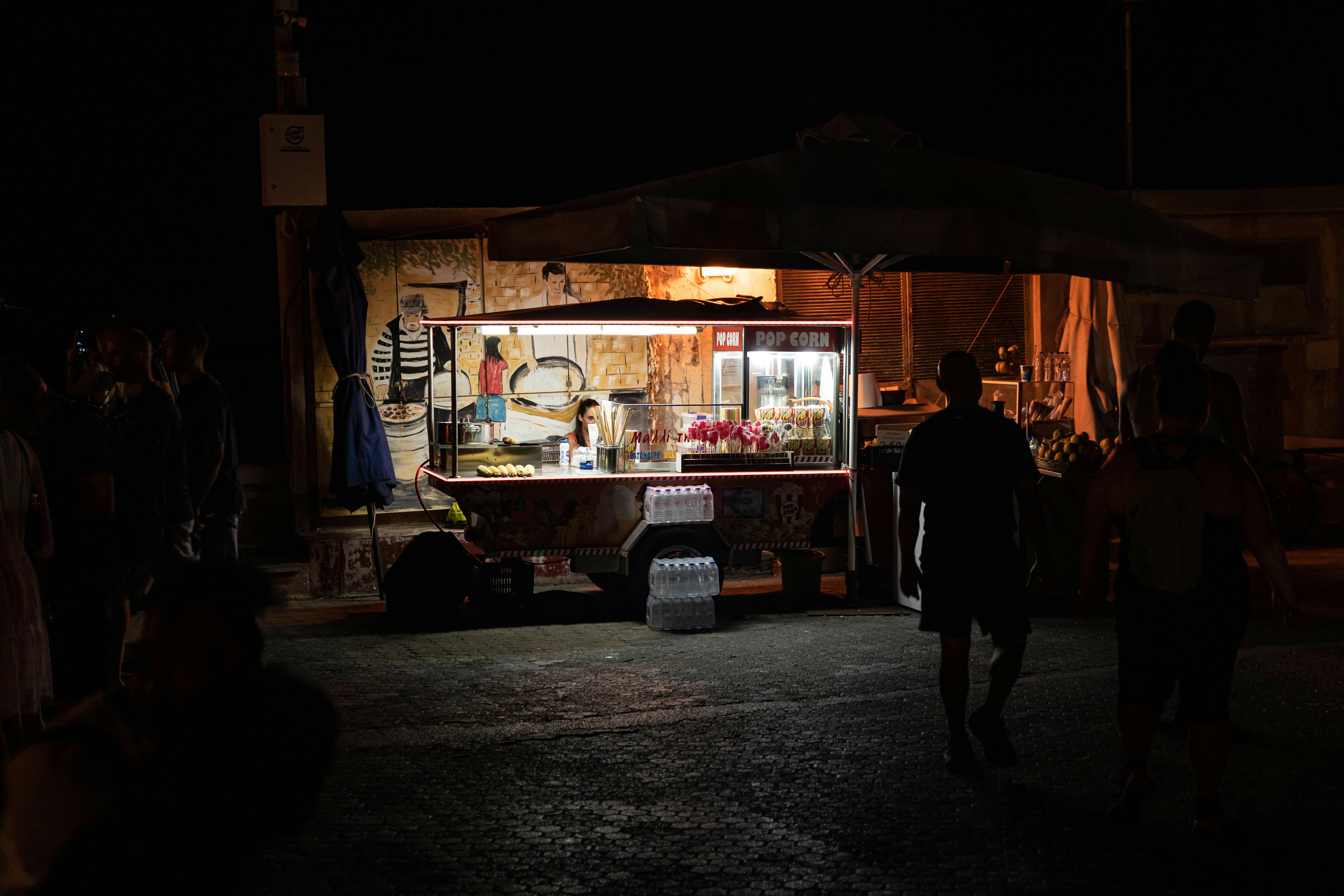 Street Food Stall next to Restaurant at Night · Free Stock Photo