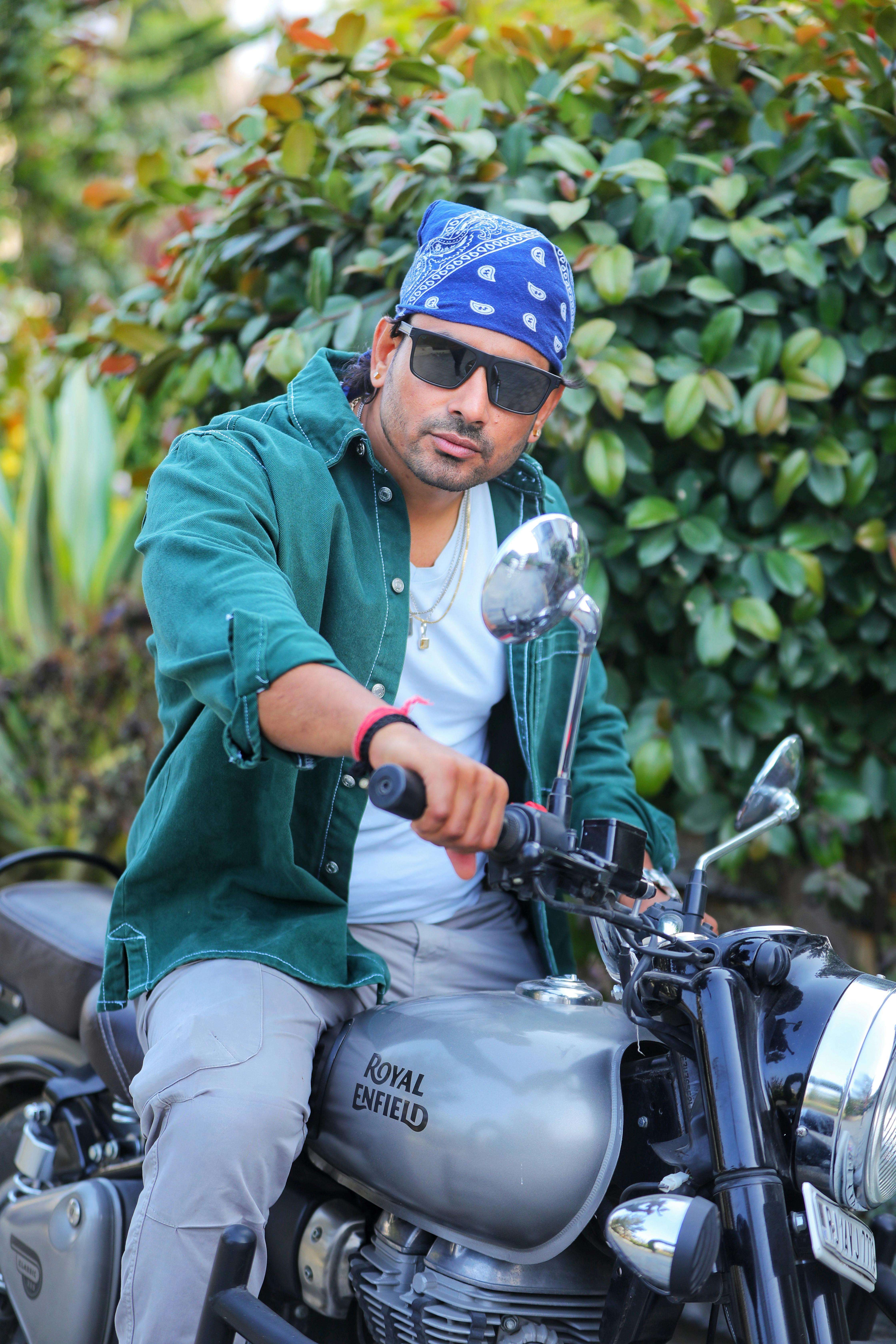 Man in a Bandana and Sunglasses Sitting on a Royal Enfield Bullet ...
