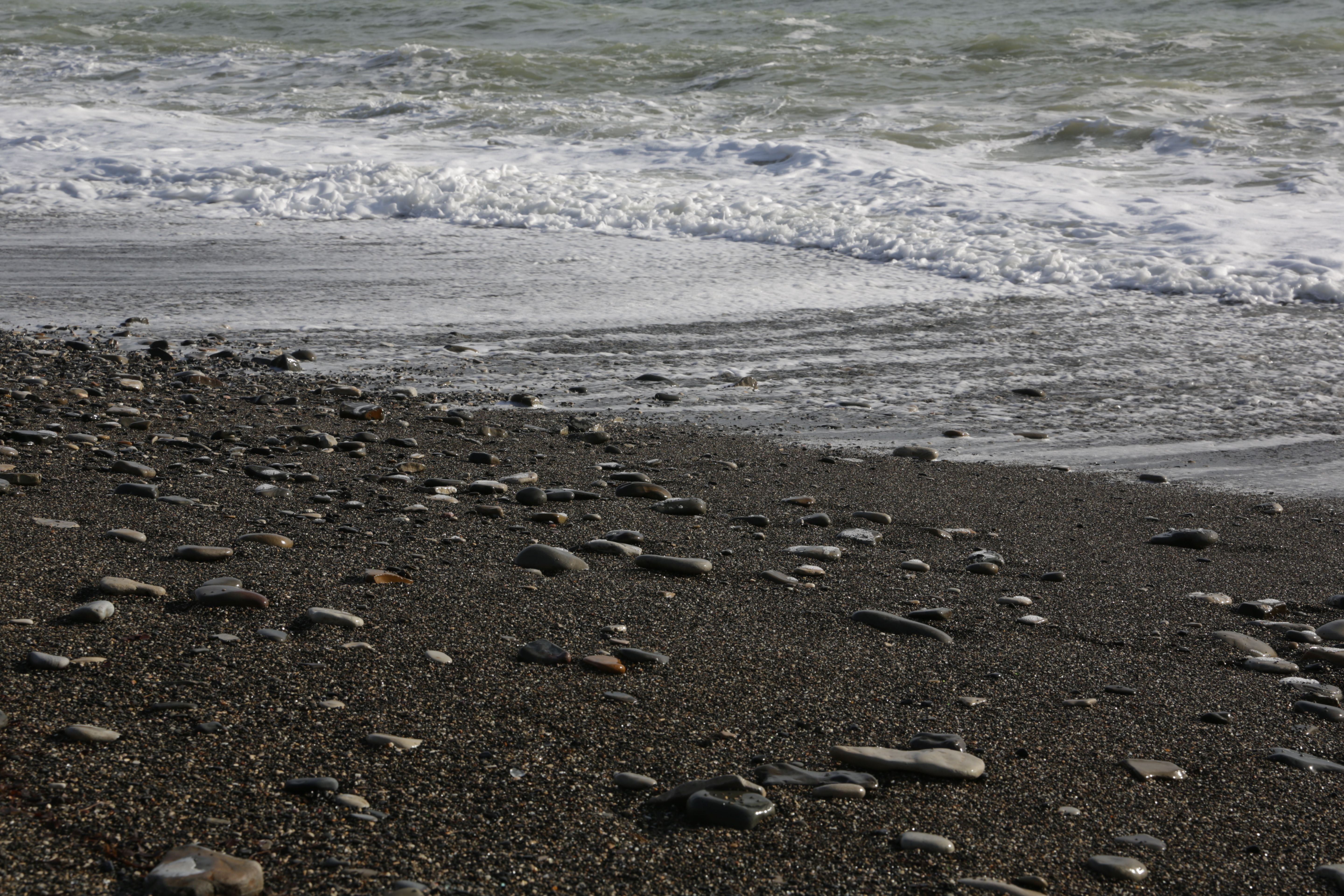 Gentle Sea Waves Rolling on a Beach with Gray Sand · Free Stock Photo