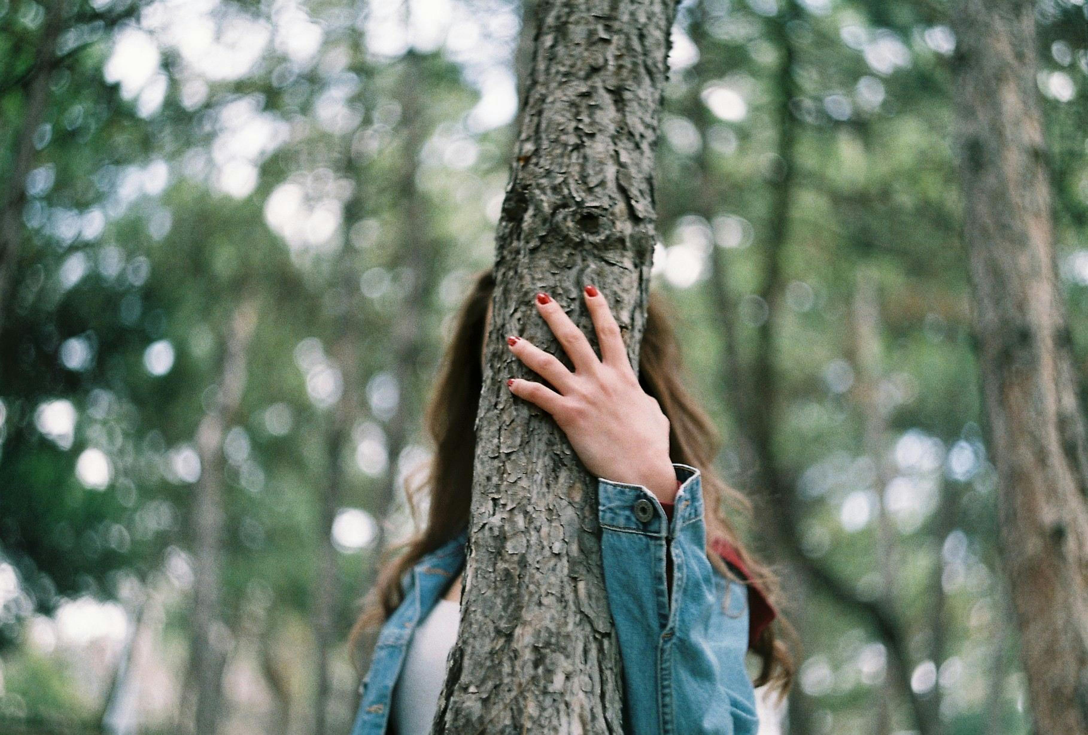 Woman in Jean Jacket Standing behind Tree · Free Stock Photo