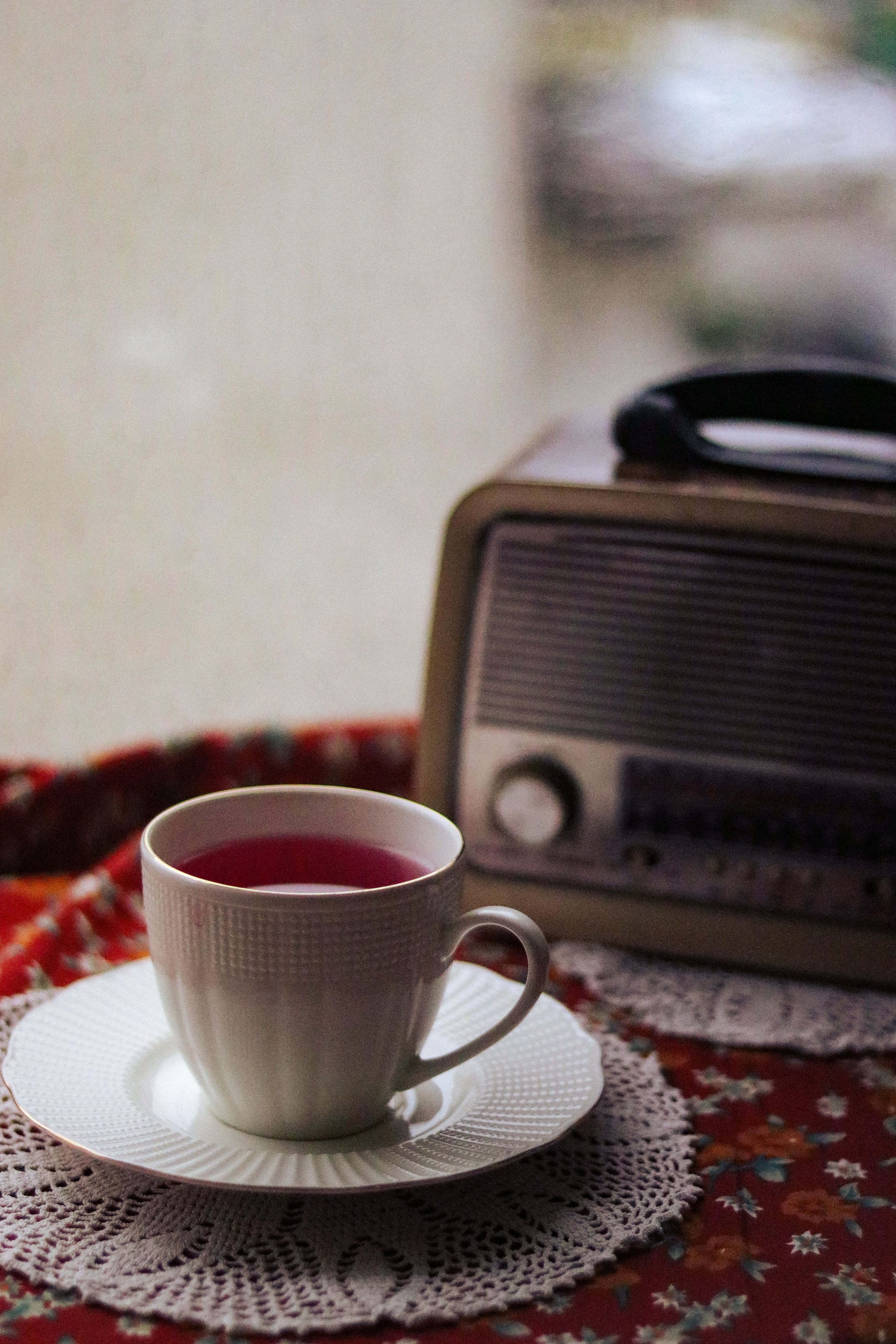 White Cup of Fruit Tea Next to a Vintage Radio · Free Stock Photo