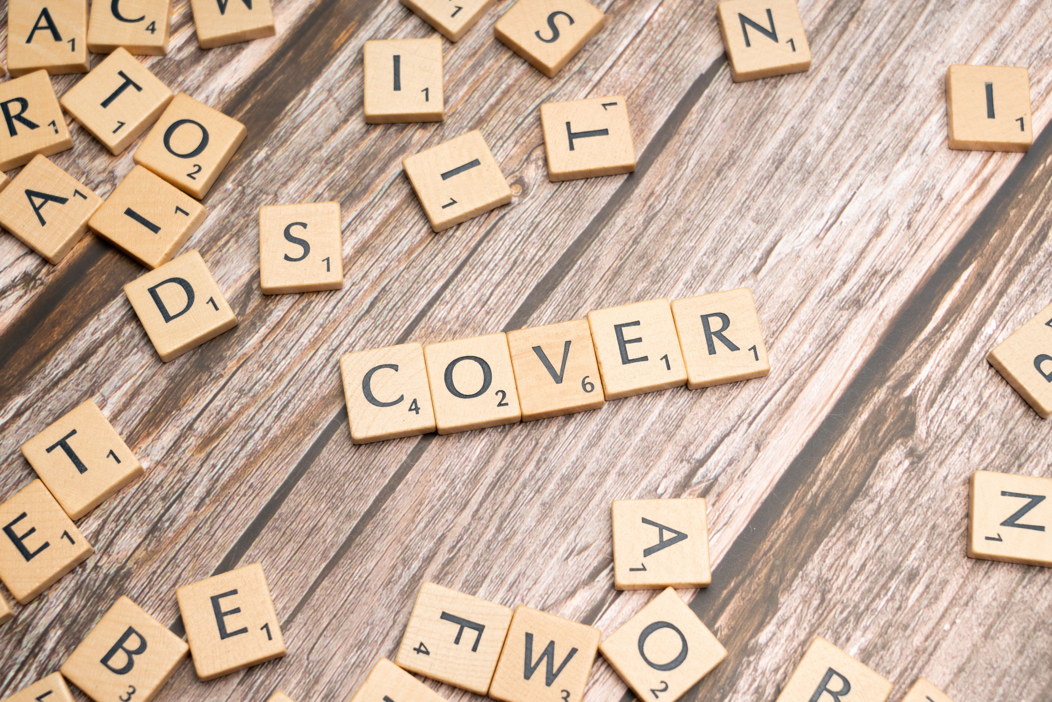The word cover spelled out with scrabble letters · Free Stock Photo