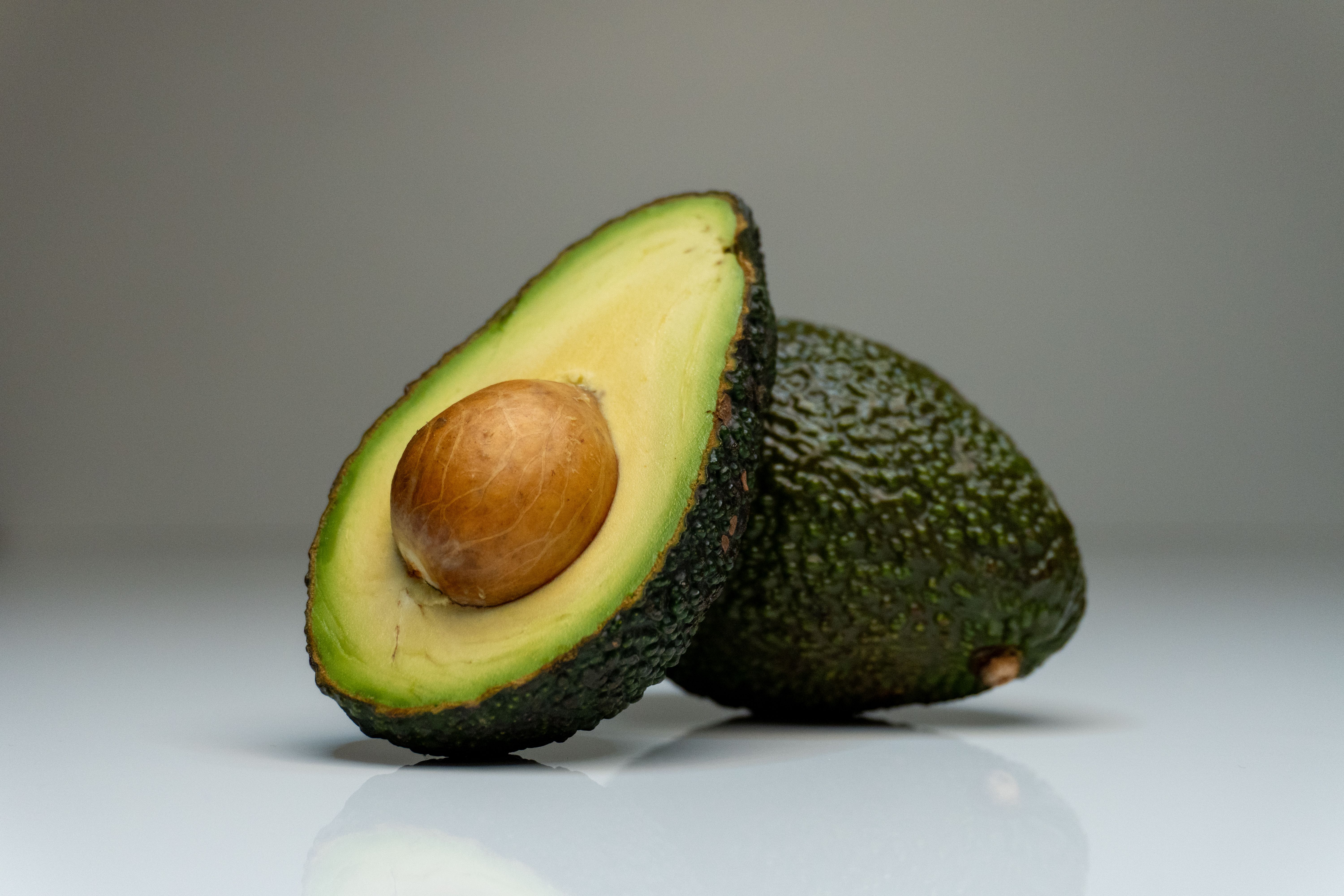 Close-up One Whole and One Cut in Half Avocado · Free Stock Photo