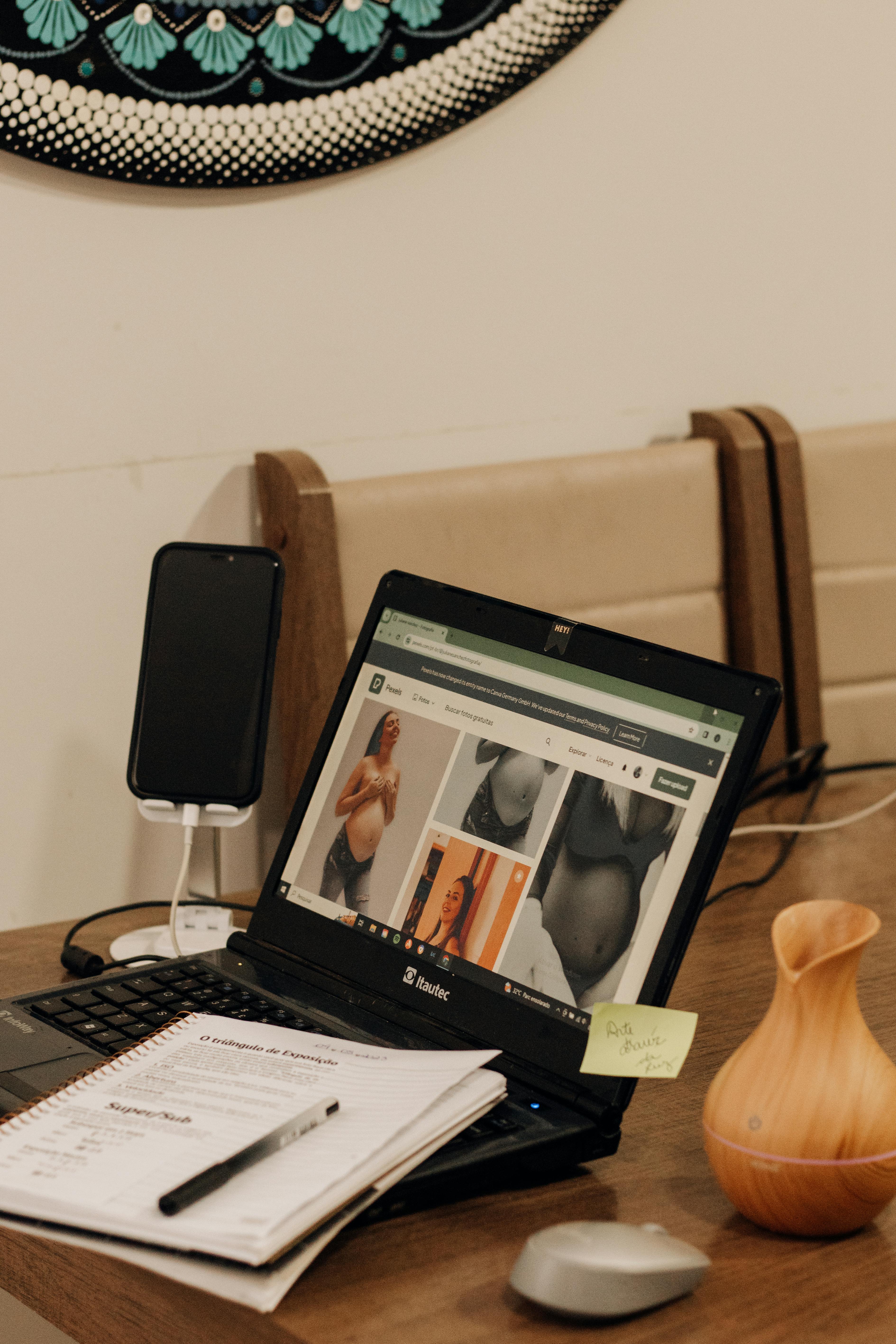 Photo of a Laptop and a Notepad · Free Stock Photo