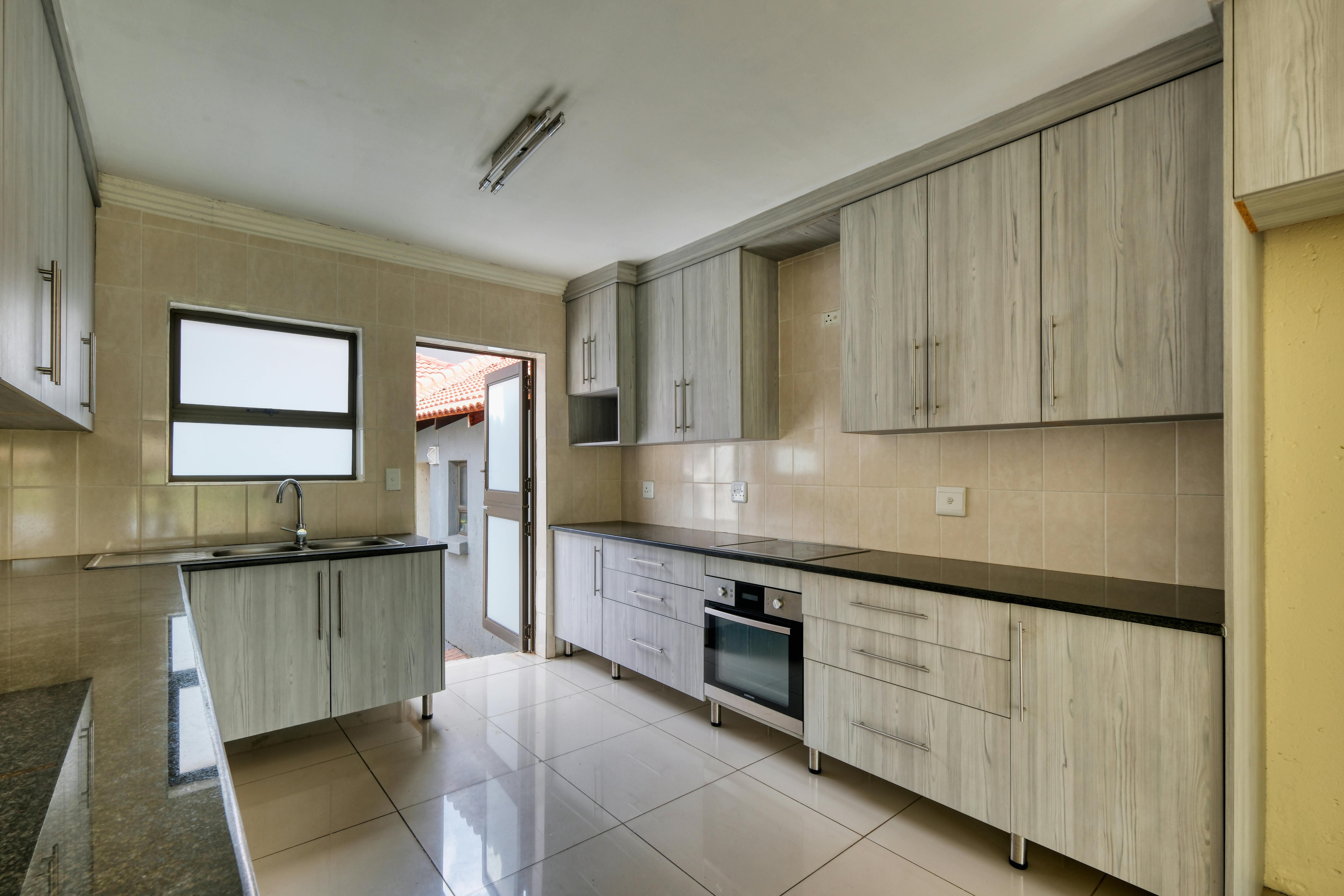 Spacious hallway leading to modern kitchen in minimalist styled house ...