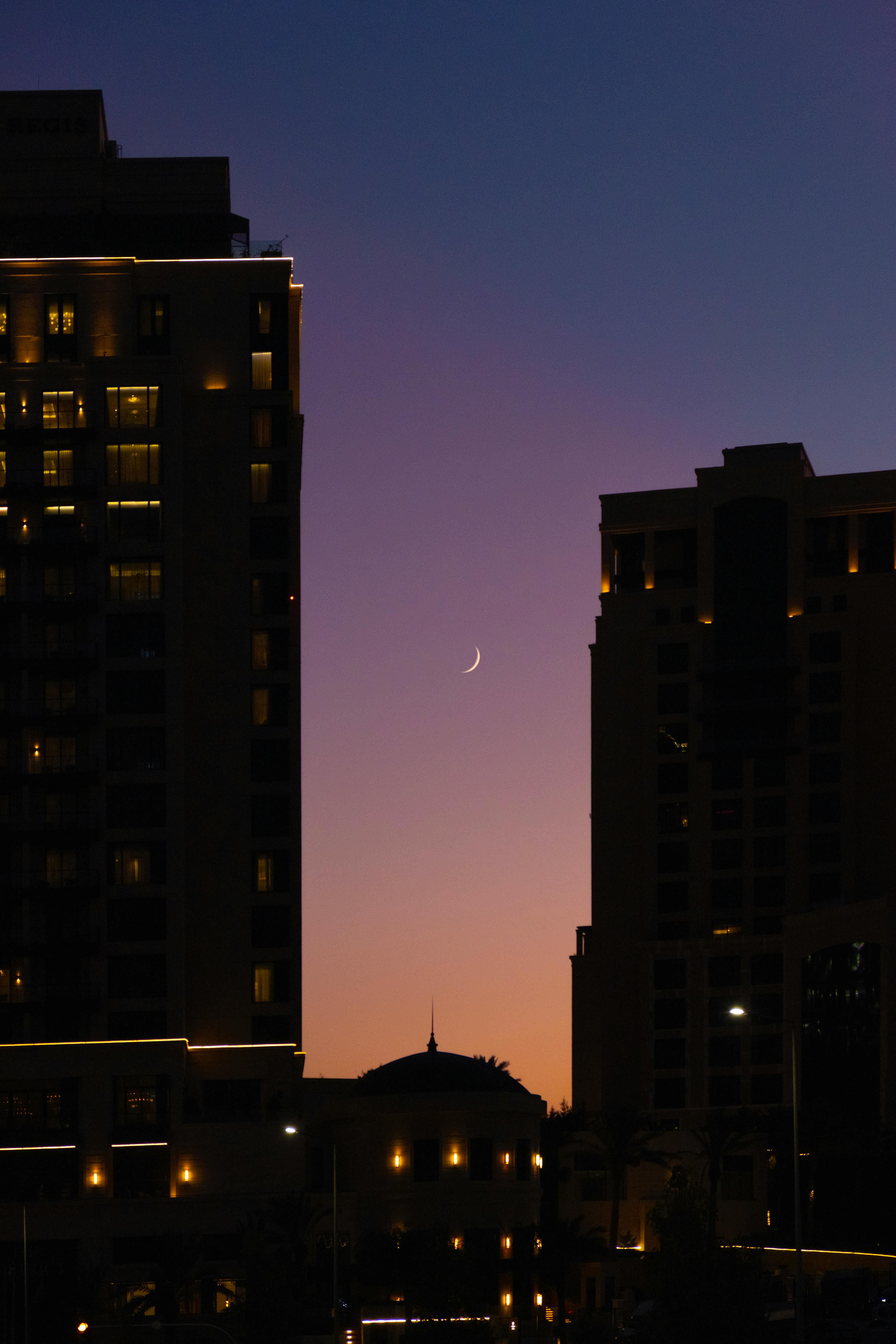 Crescent Moon in the Evening Sky Between High-rise Buildings · Free ...