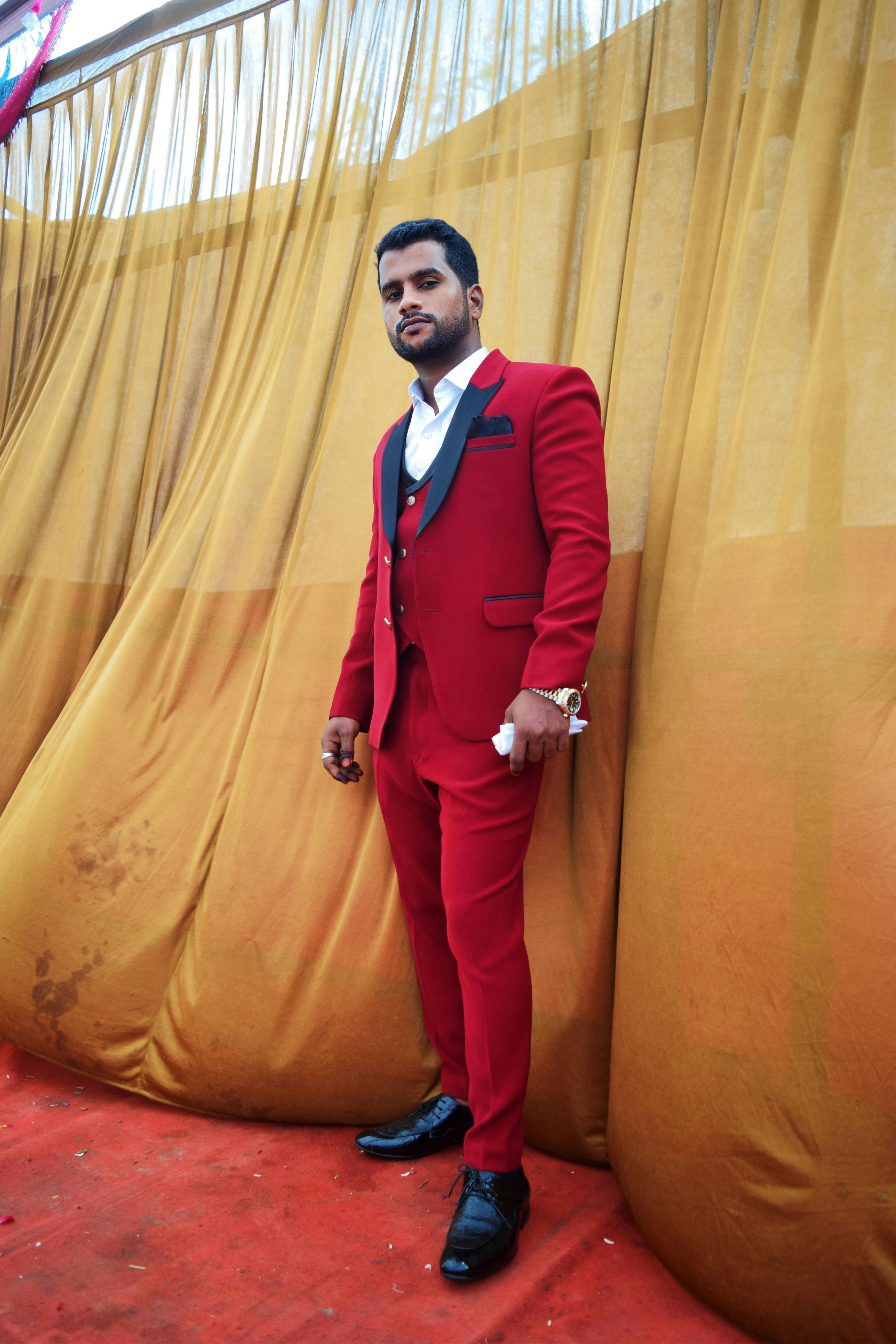 Elegant Man in Red Suit Standing by Curtain · Free Stock Photo
