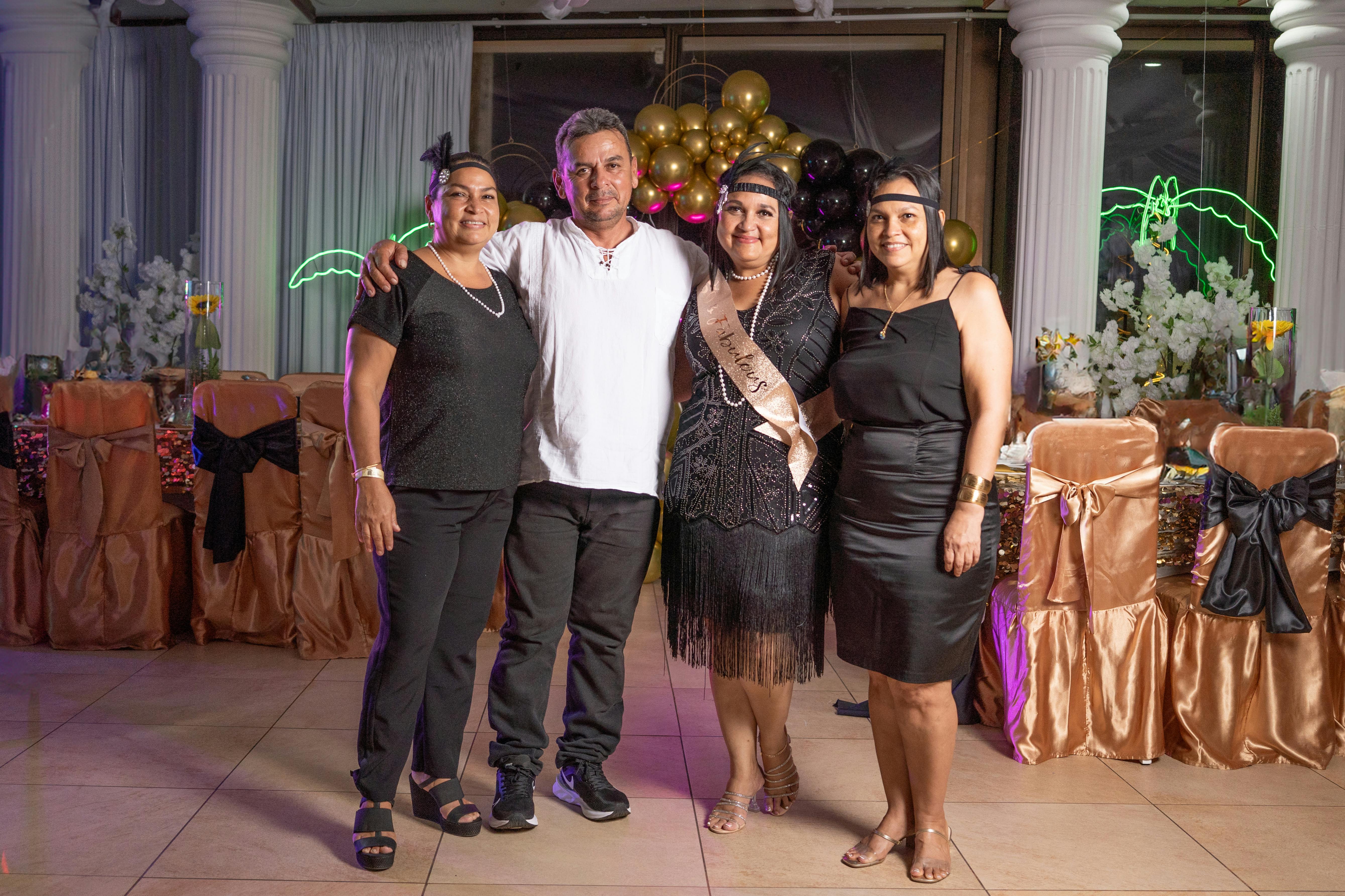 Three people standing together in a room with a table · Free Stock Photo
