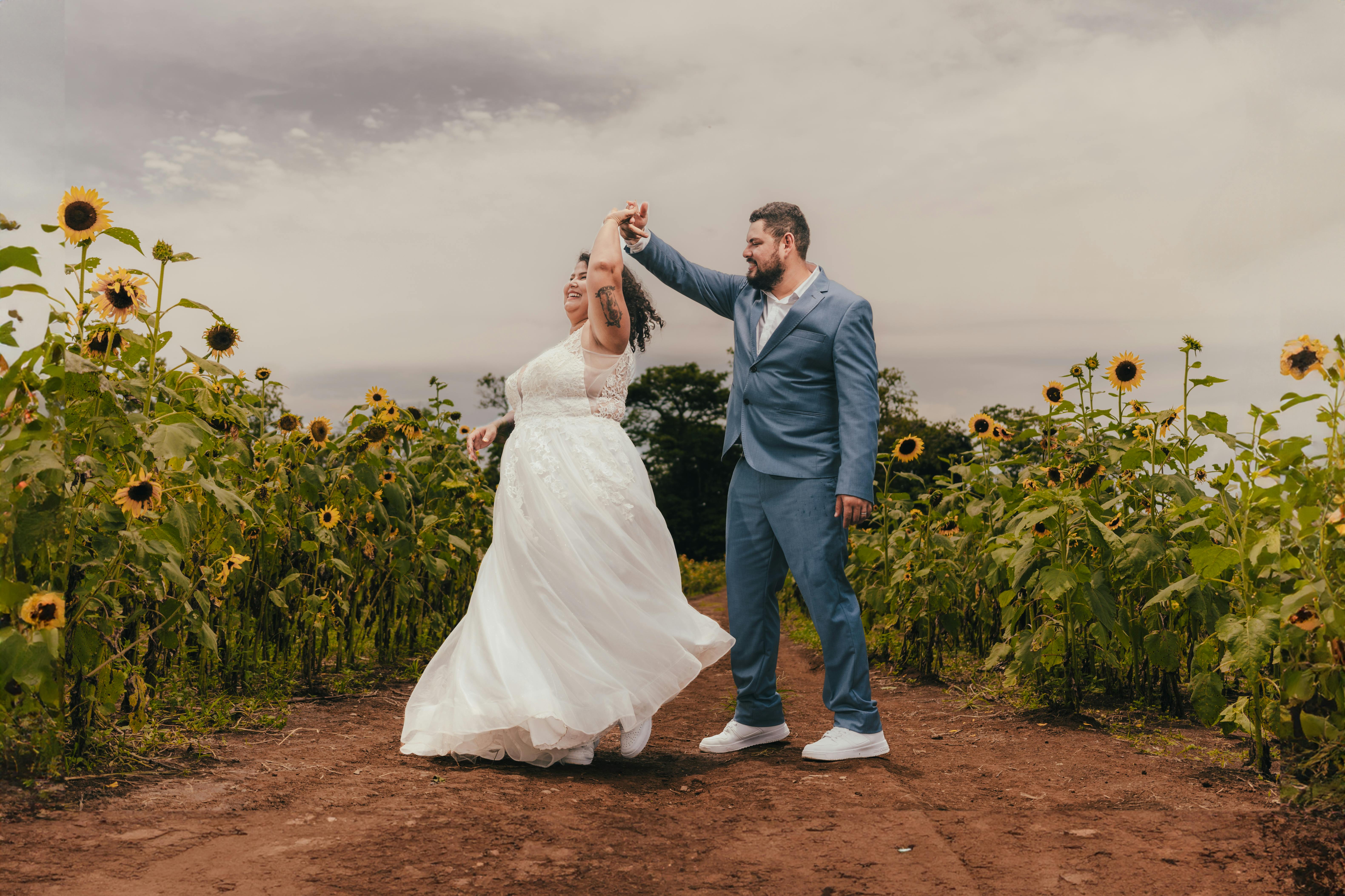 Newlywed Couple Dancing among Sunflowers · Free Stock Photo