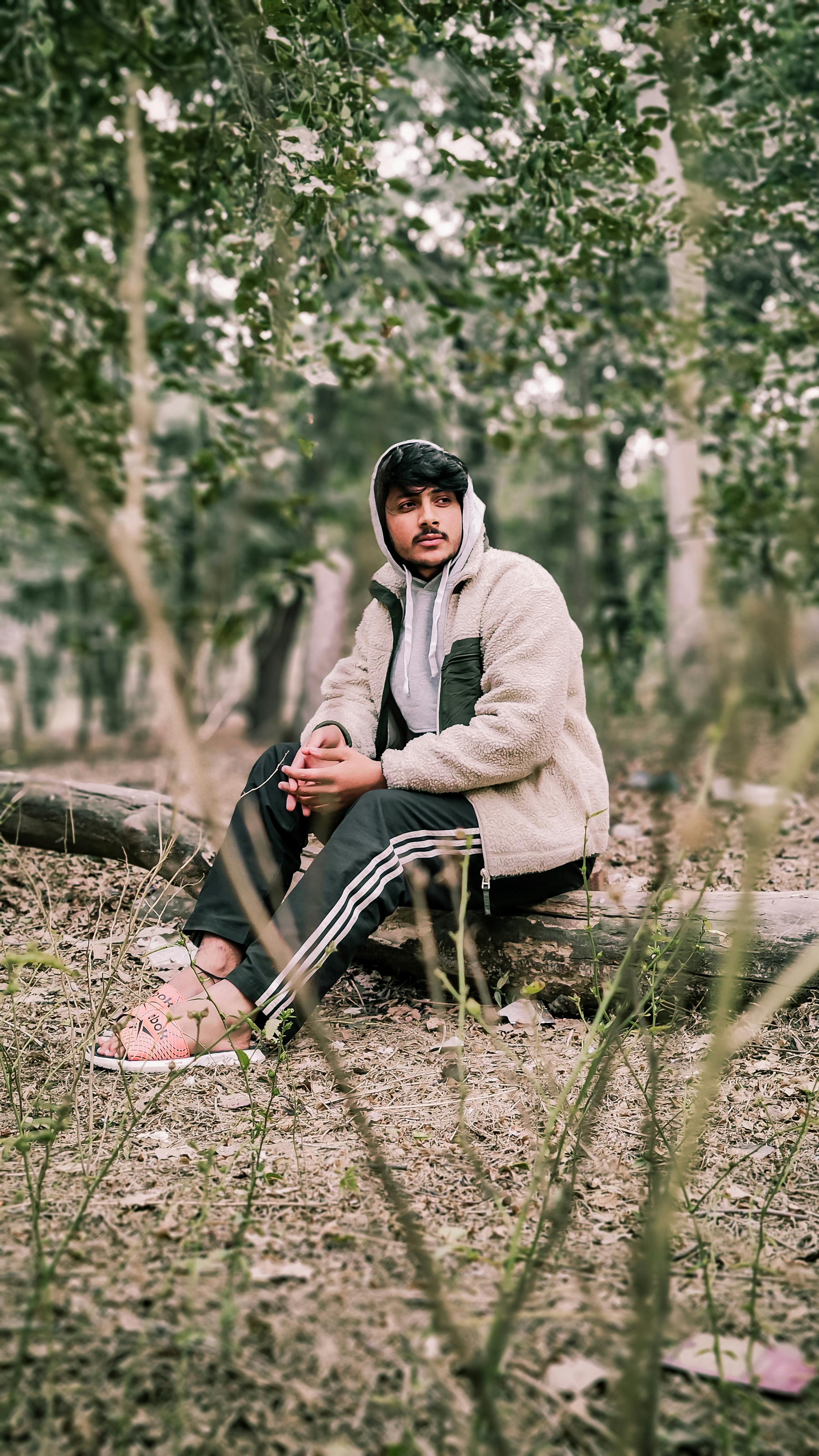 Man Sitting on Fallen Tree in Park · Free Stock Photo
