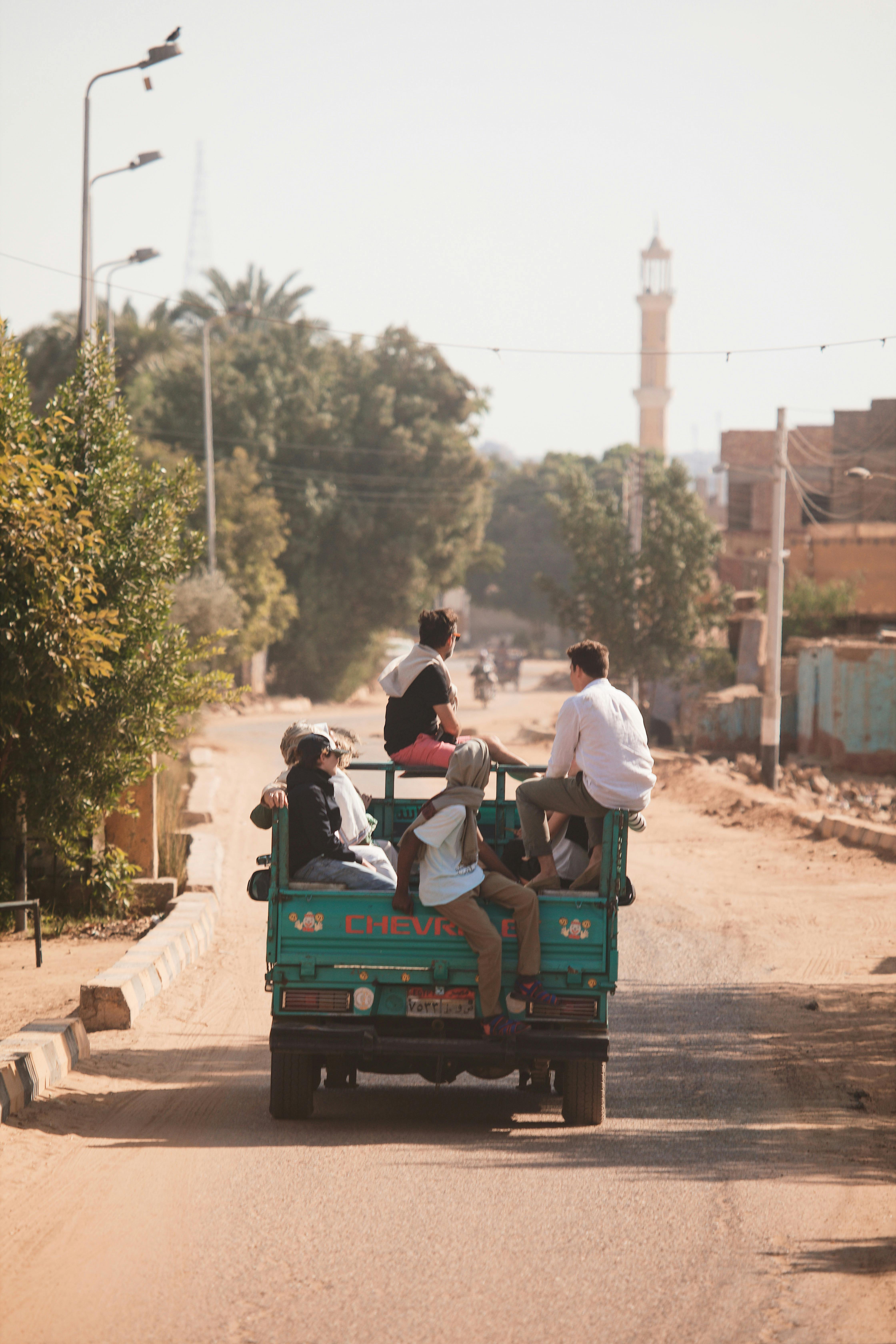 A group of people riding in the back of a truck · Free Stock Photo