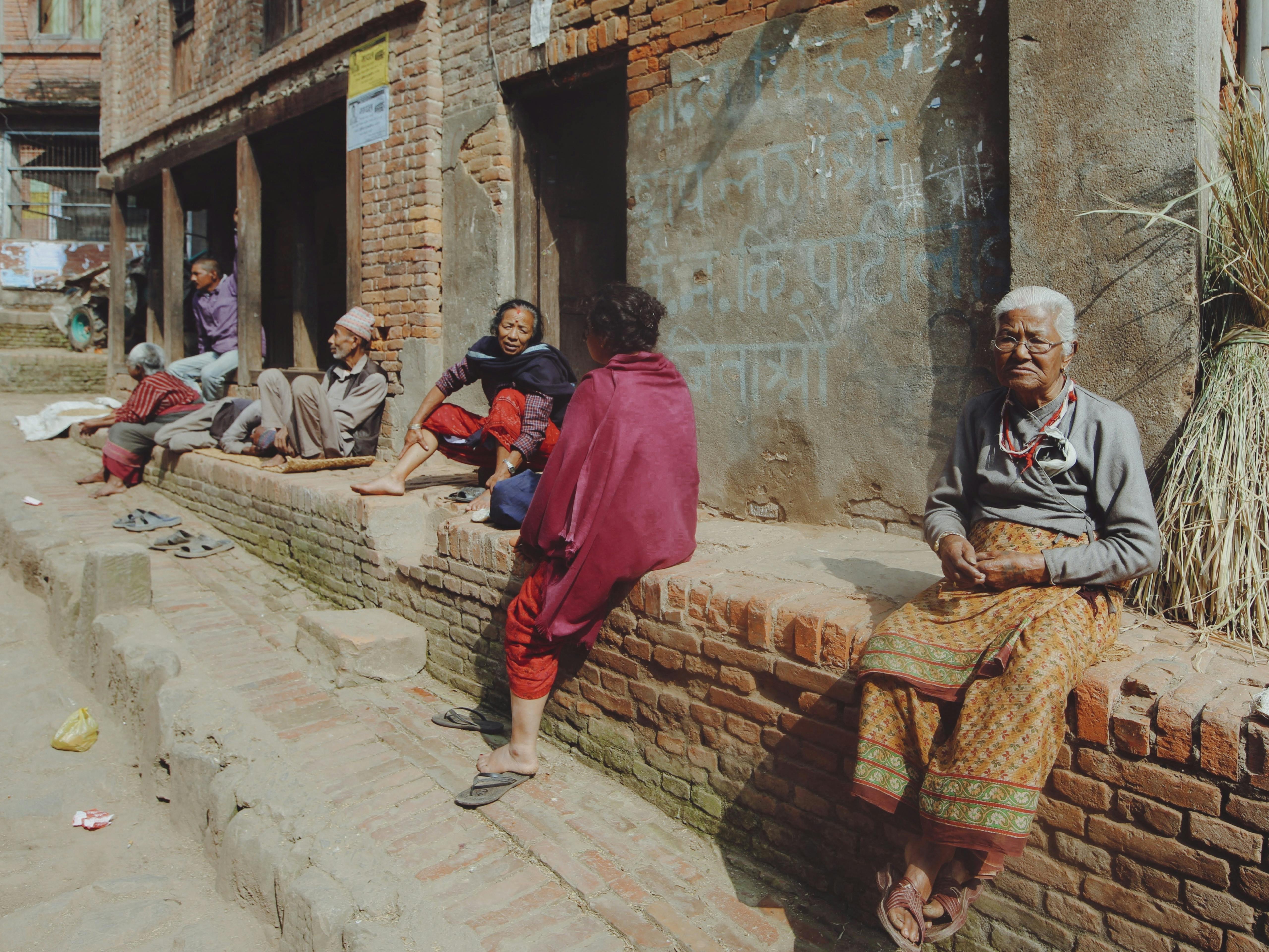 People Sitting on Wall in Village · Free Stock Photo
