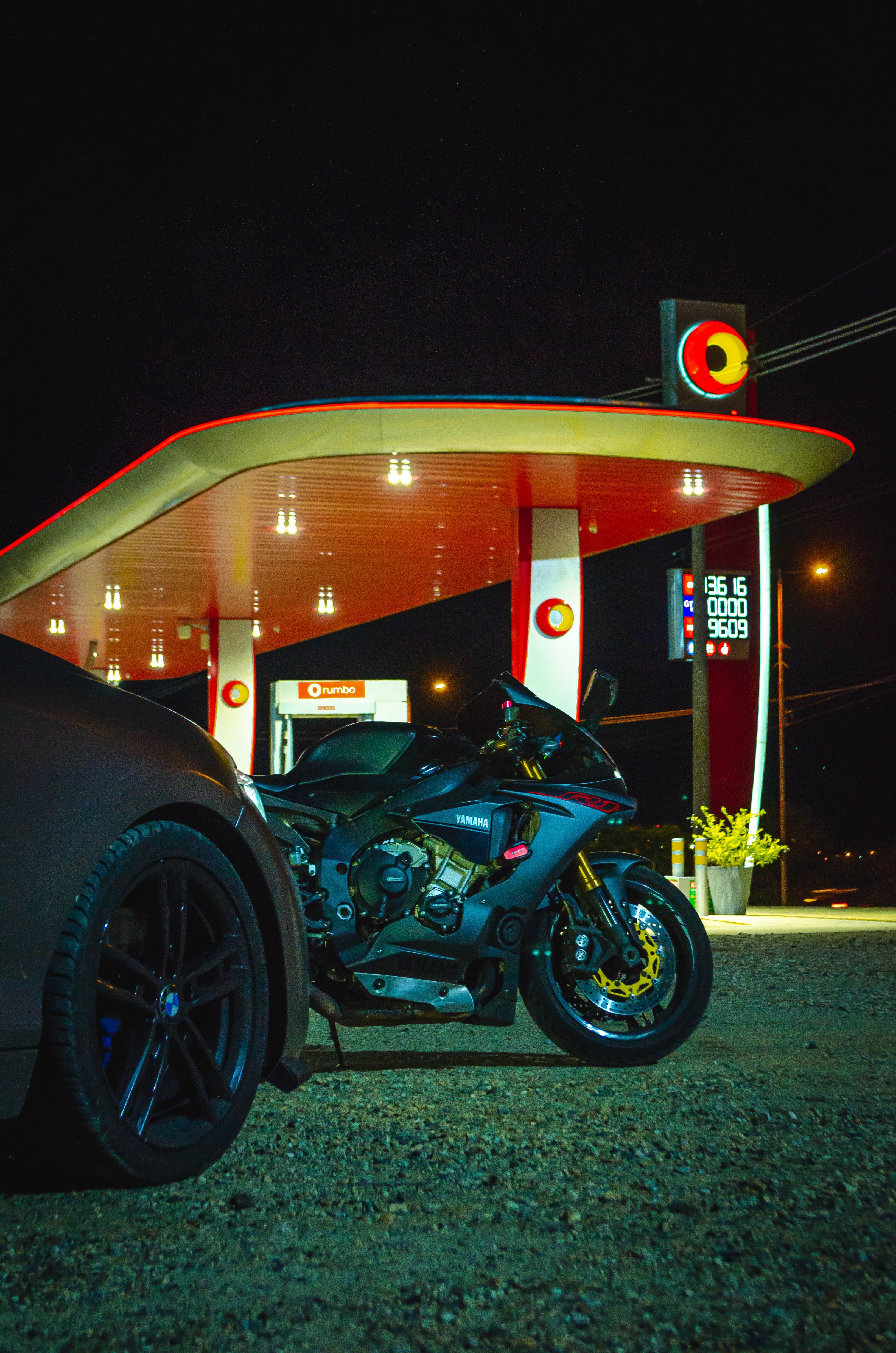 Black Motorcycle Standing in Front of an Illuminated Filling Station at ...