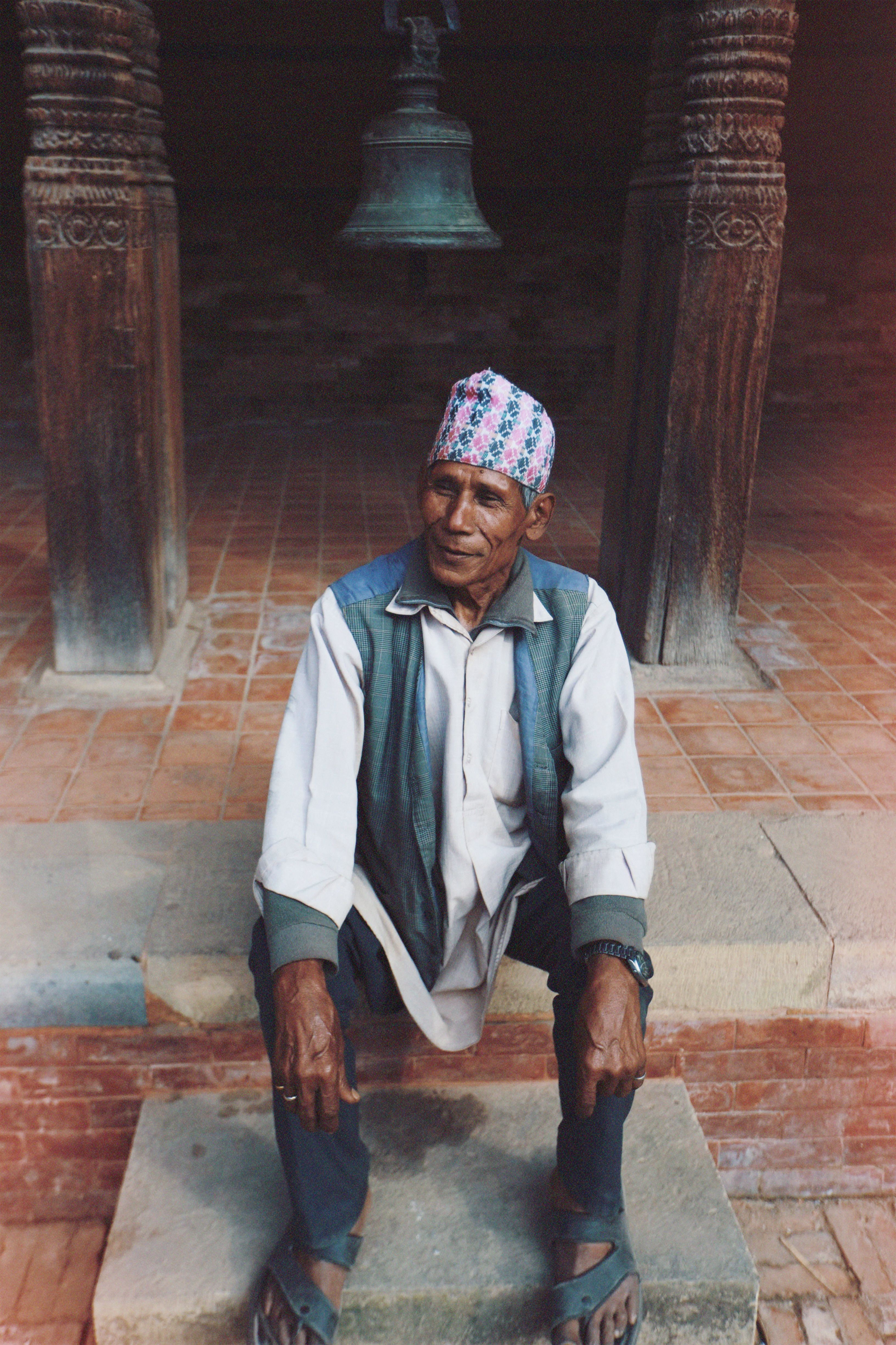 Man Sitting near Bell at Buddhist Temple · Free Stock Photo