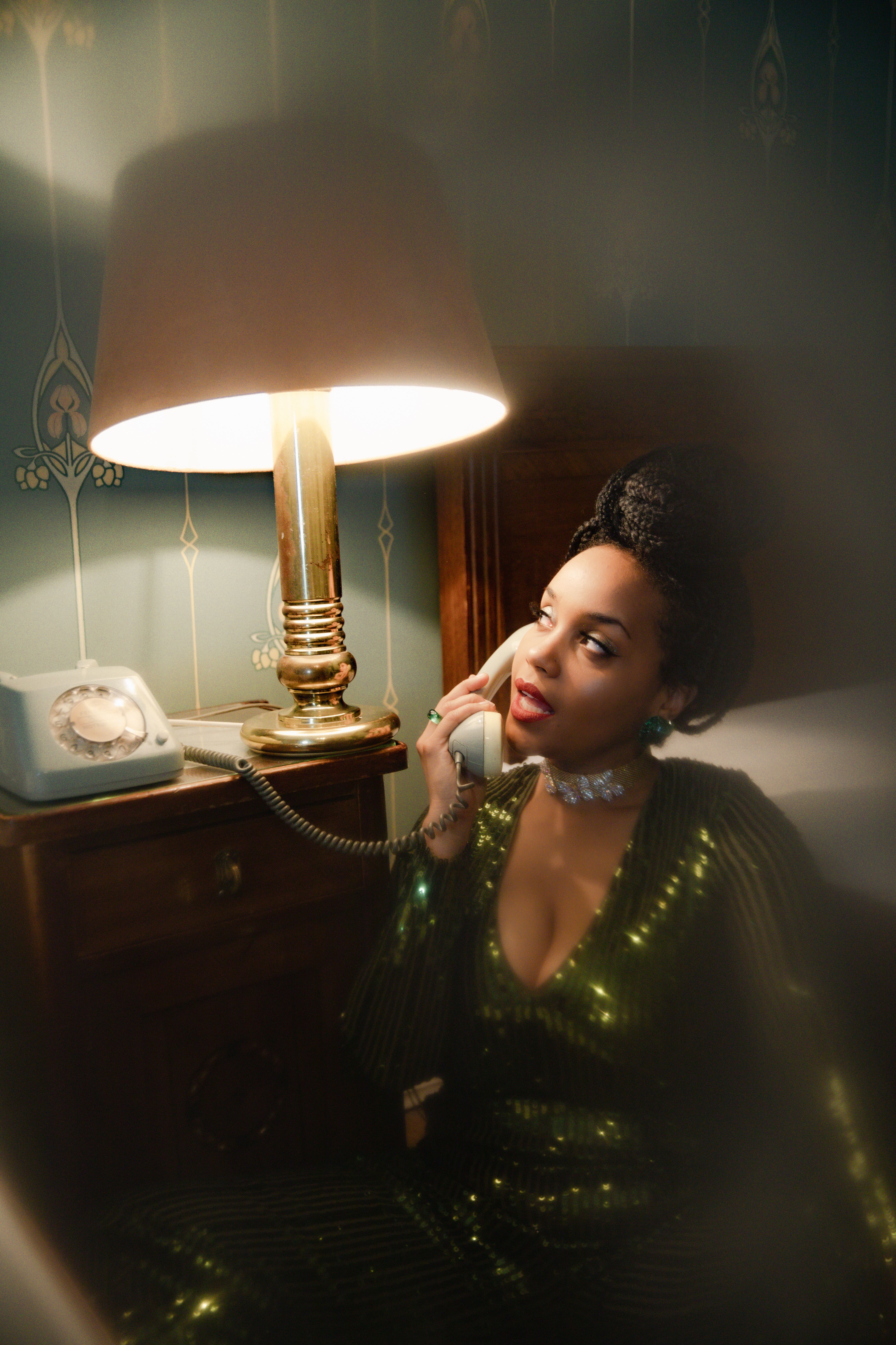 Woman in Glistening Green Dress Using Analog Telephone · Free Stock Photo