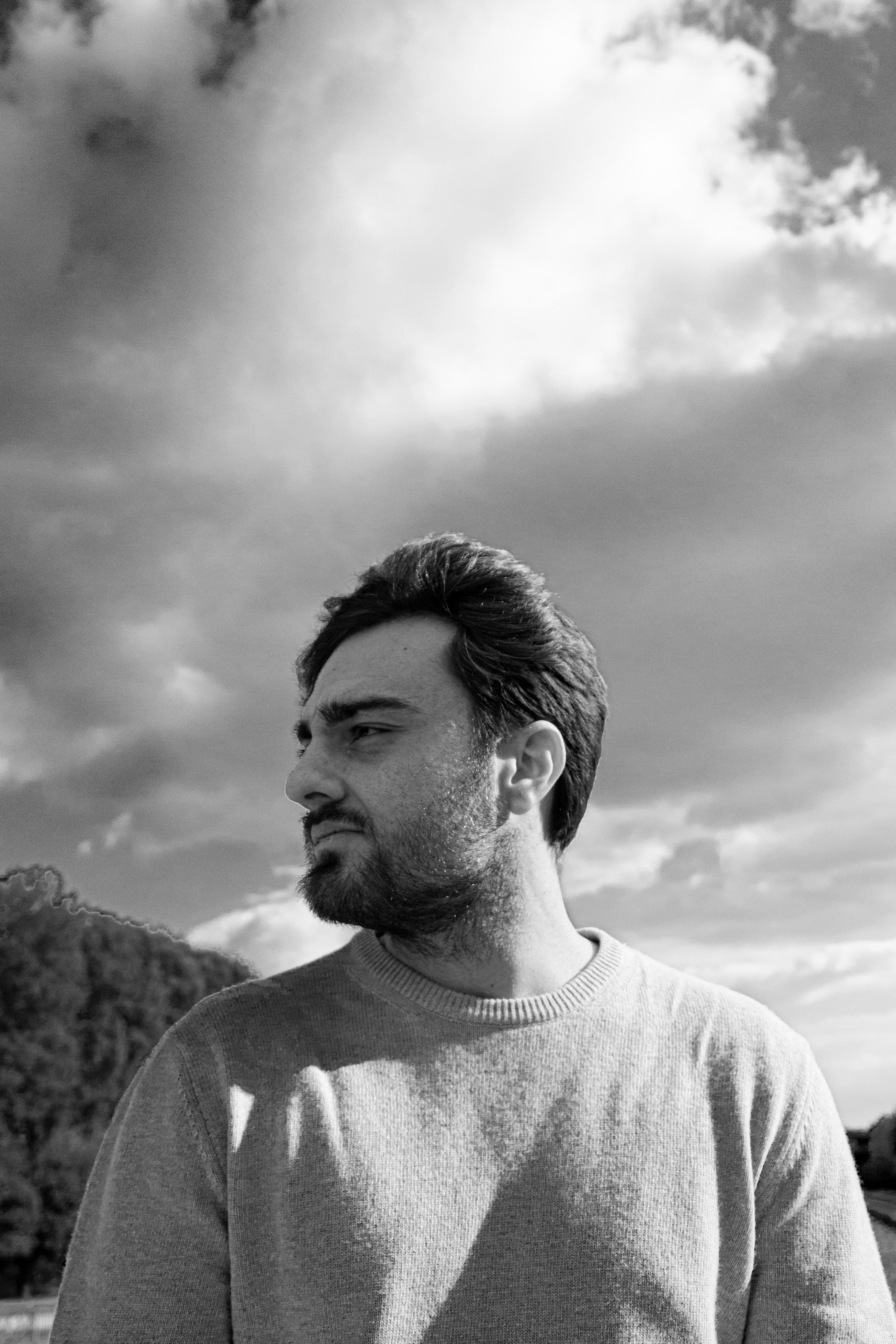 A man in a grey sweater looking up at the sky · Free Stock Photo