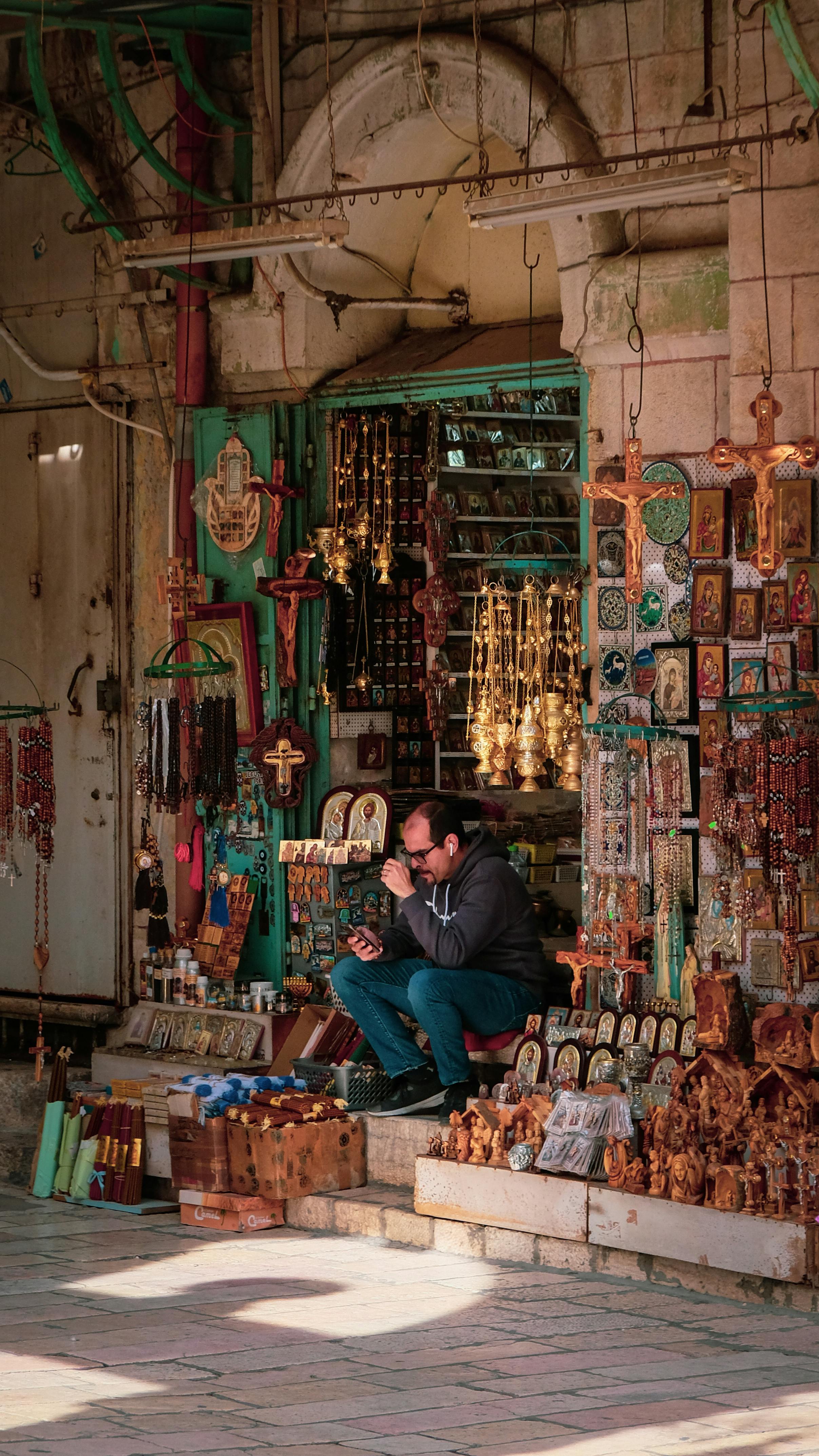 Man Sitting in Store Entrance · Free Stock Photo