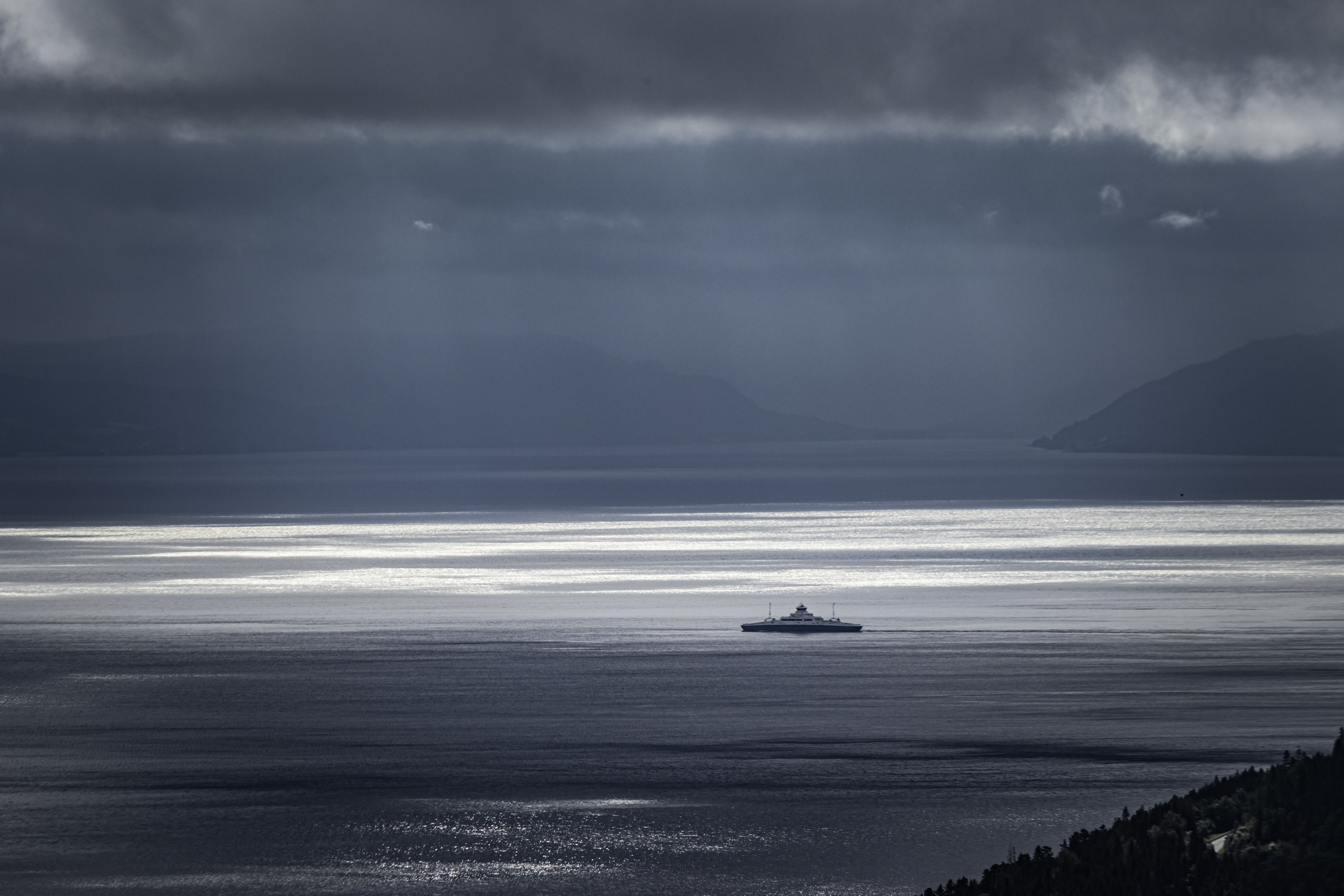 A ferry on a stormy fjord bathed in sun in Norway · Free Stock Photo
