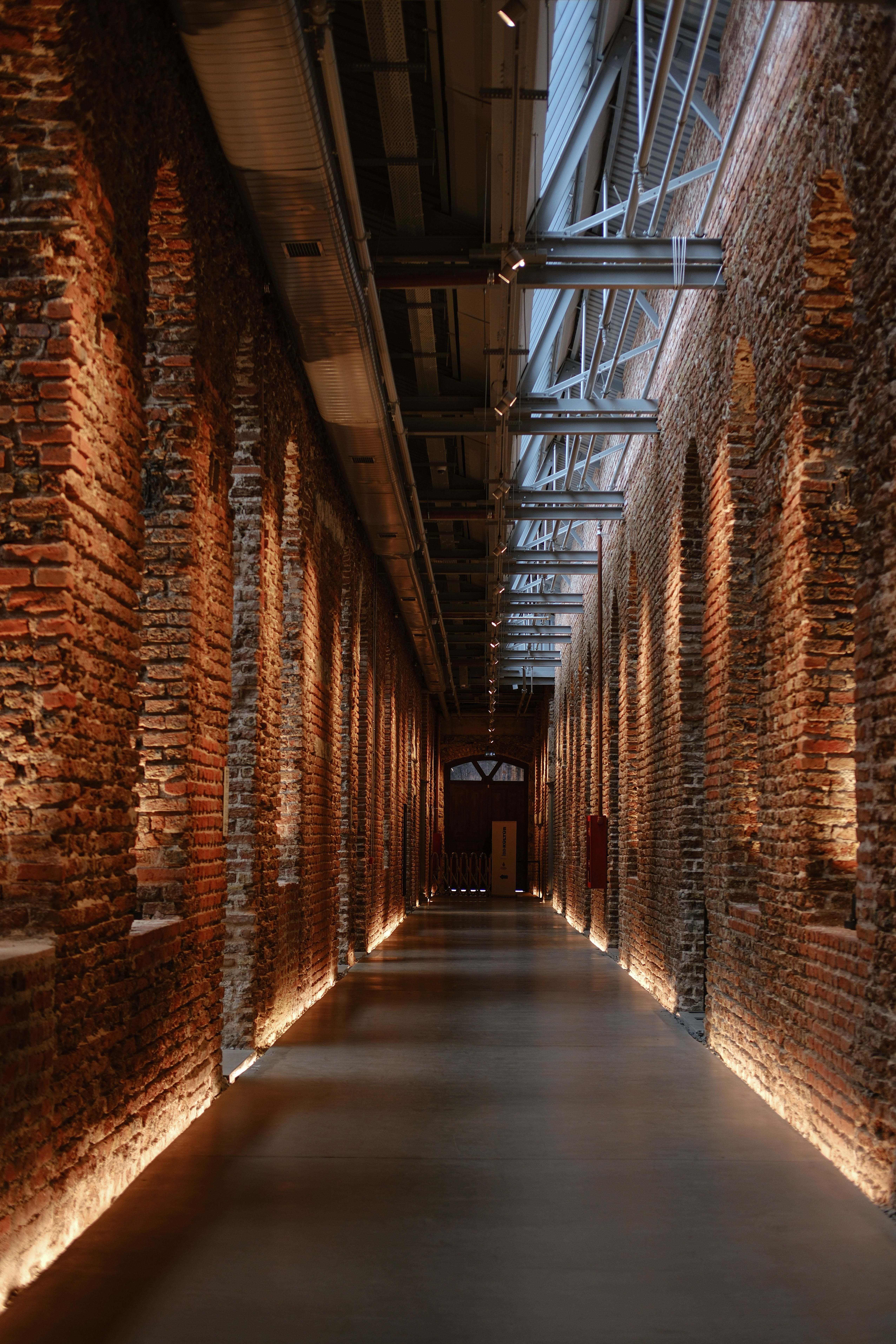 The long walkway in a brick building with lights · Free Stock Photo