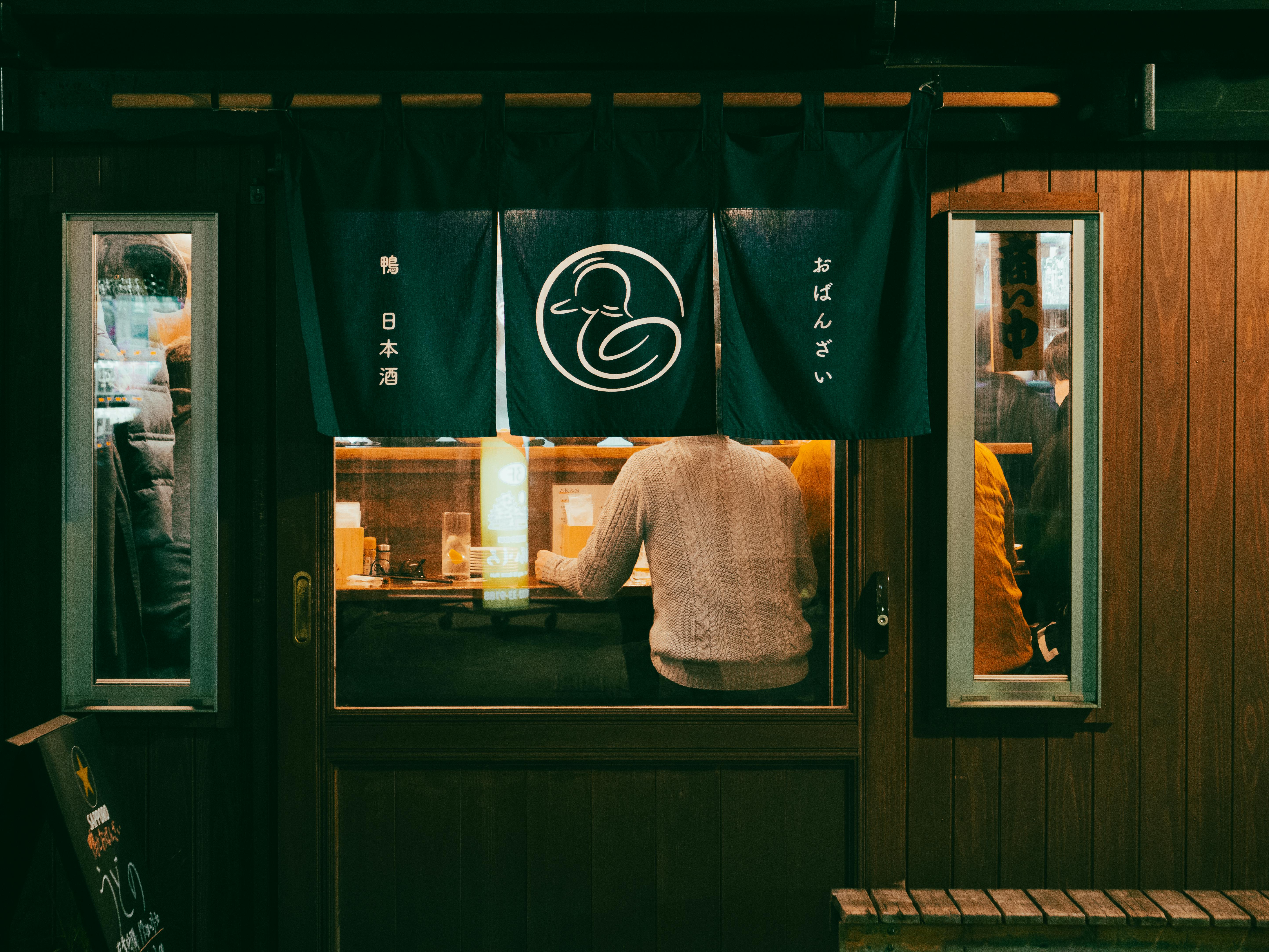 Person Sitting behind Cafe Window · Free Stock Photo