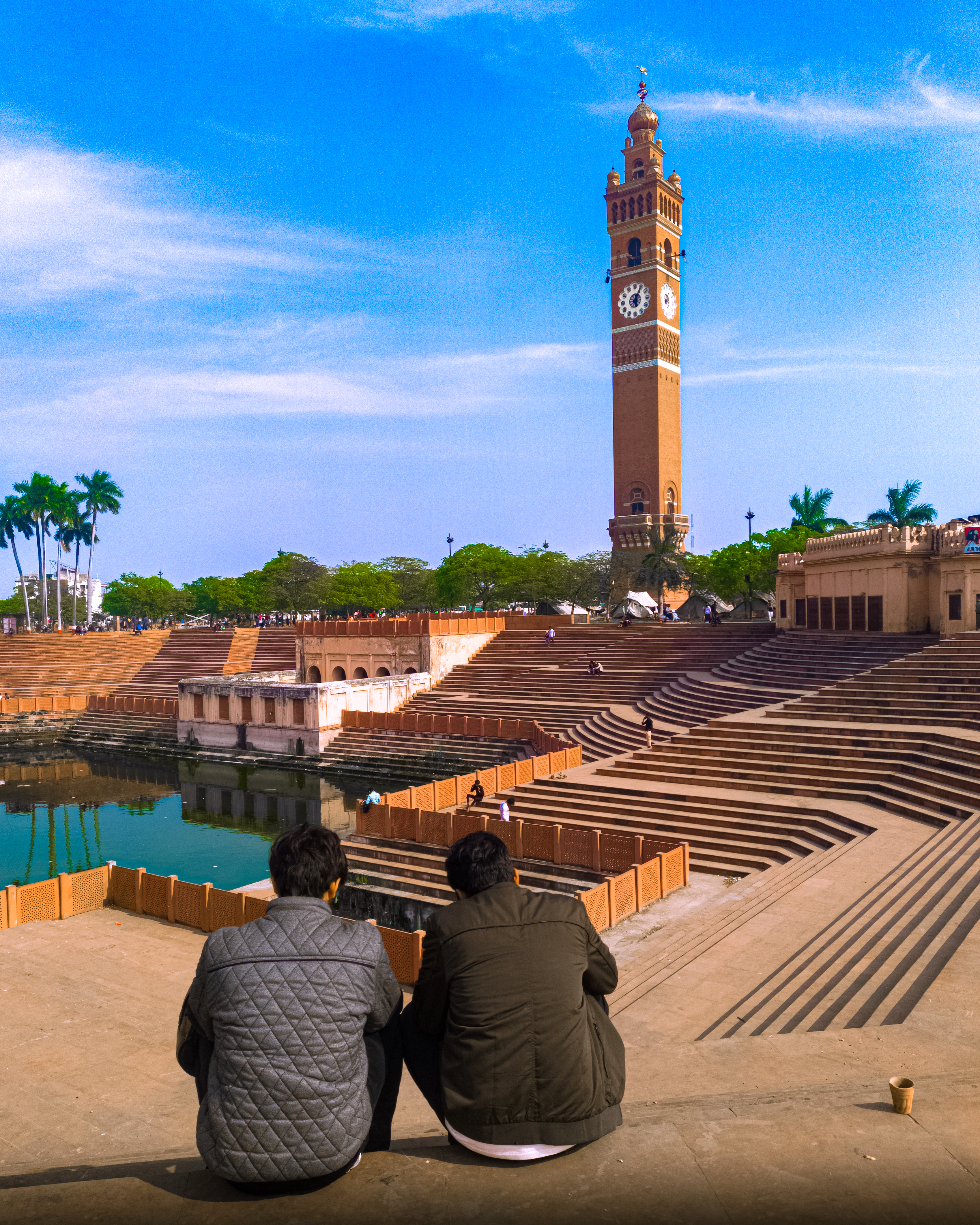 Back View of Men Sitting on Steps with View of the Husainabad Clock ...