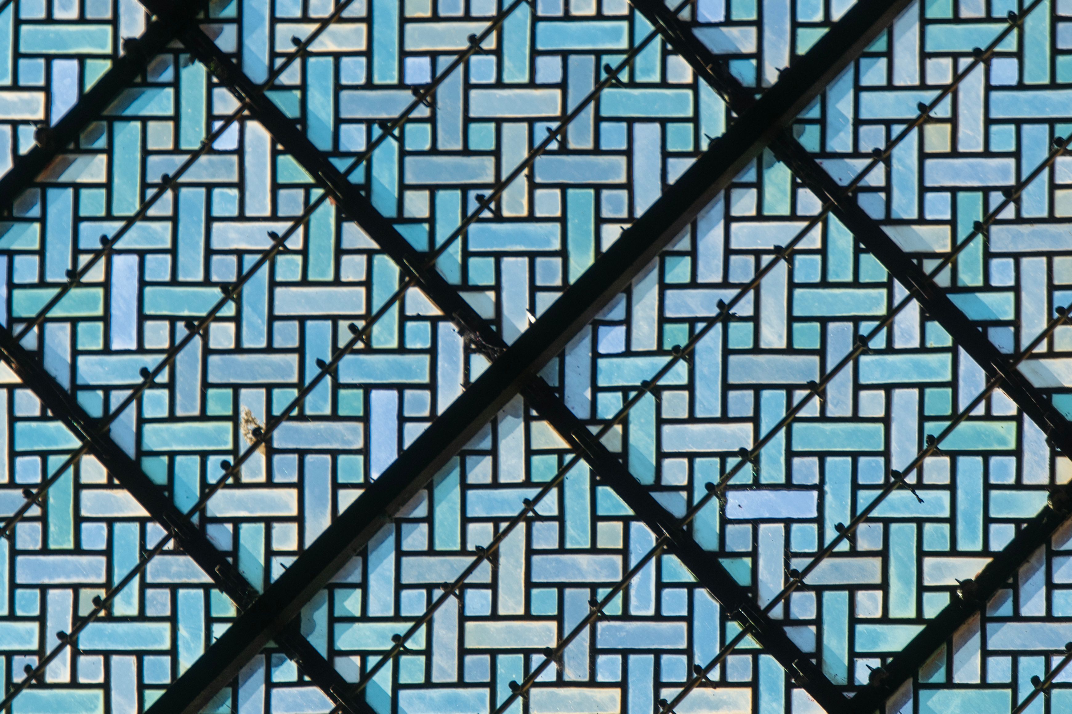 A blue and white stained glass window with squares · Free Stock Photo