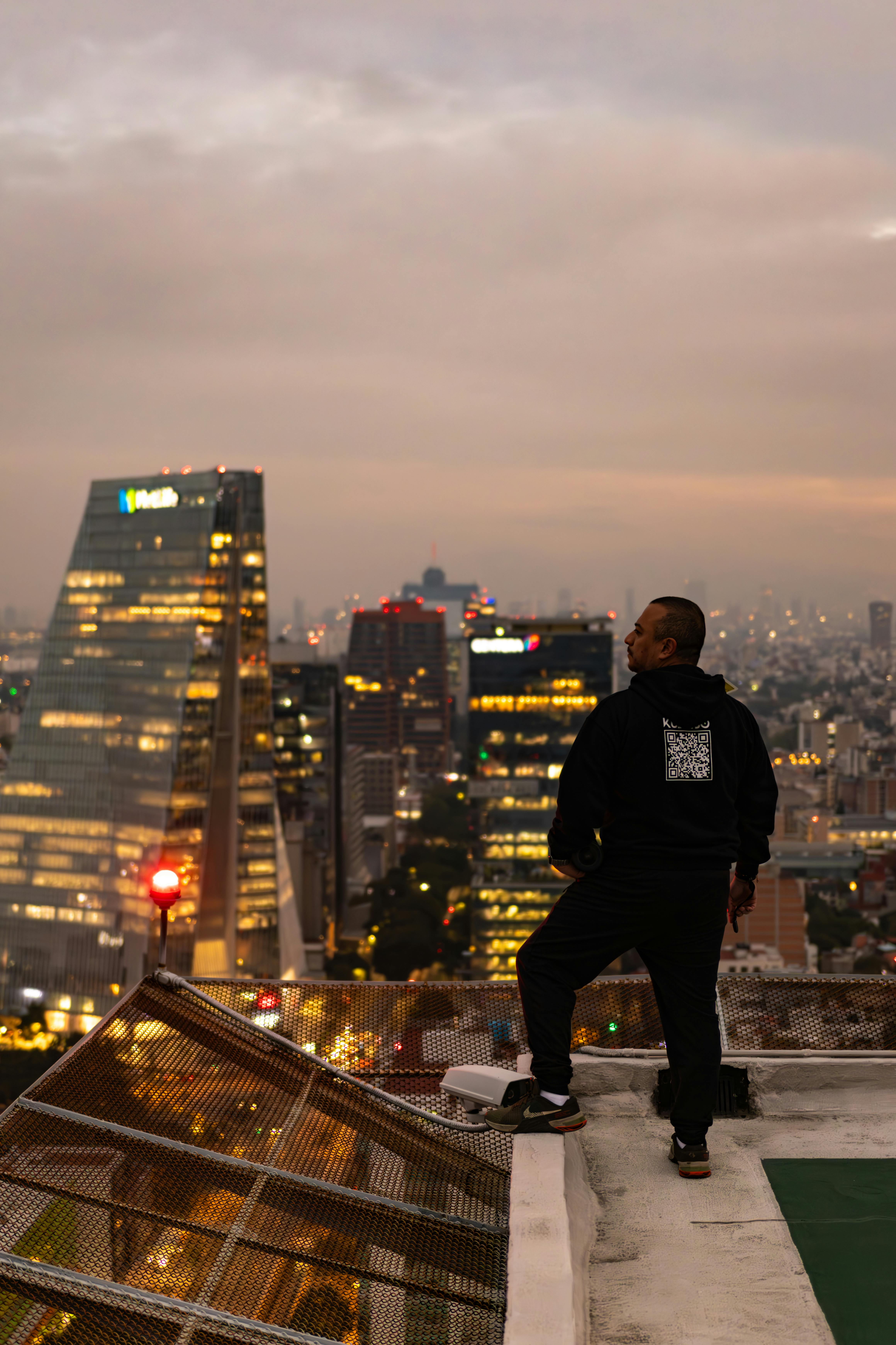 Man Standing on Roof over City Skyscrapers · Free Stock Photo