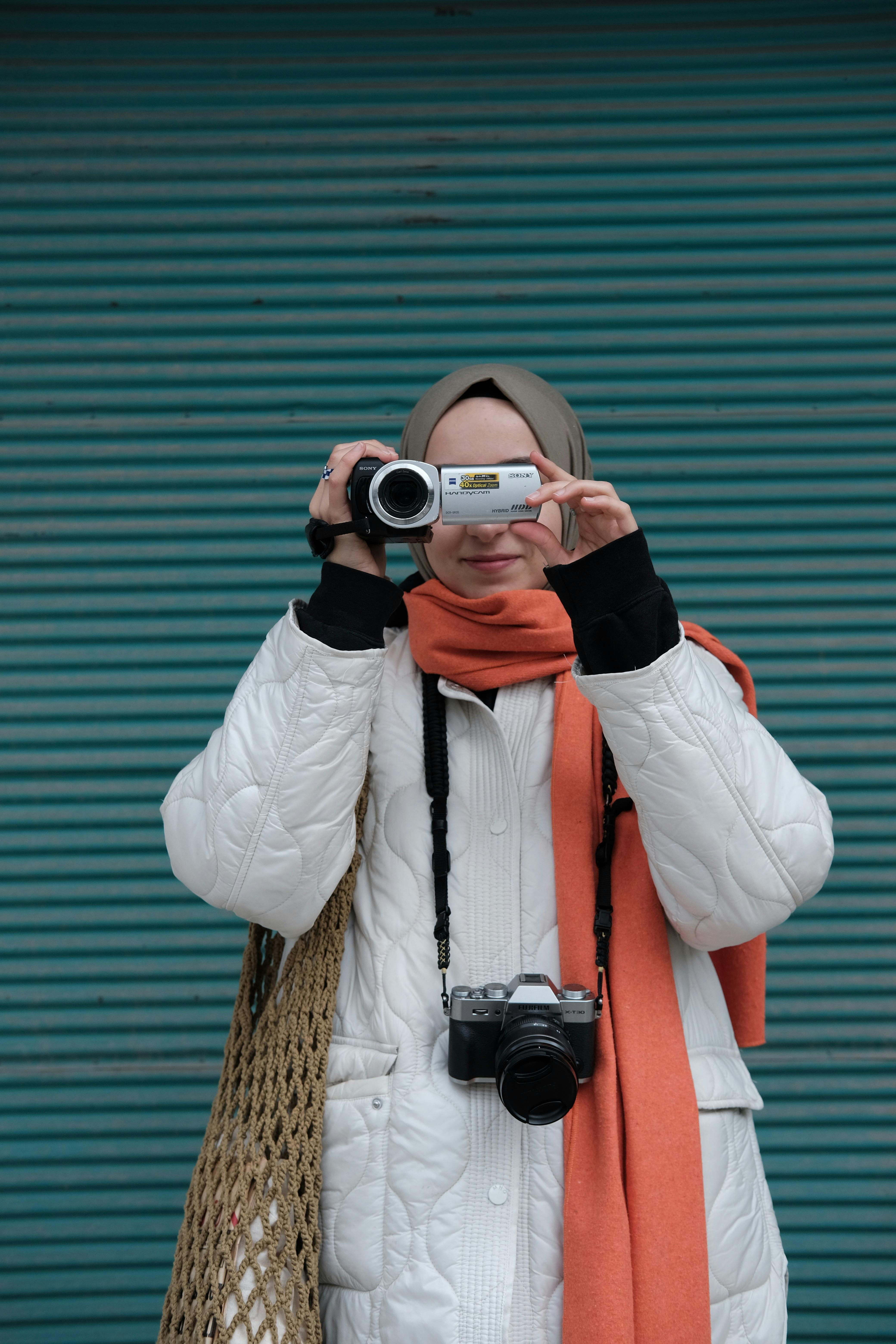 Woman with a Camera Hanging from Her Neck Filming with a Sony Handycam ...