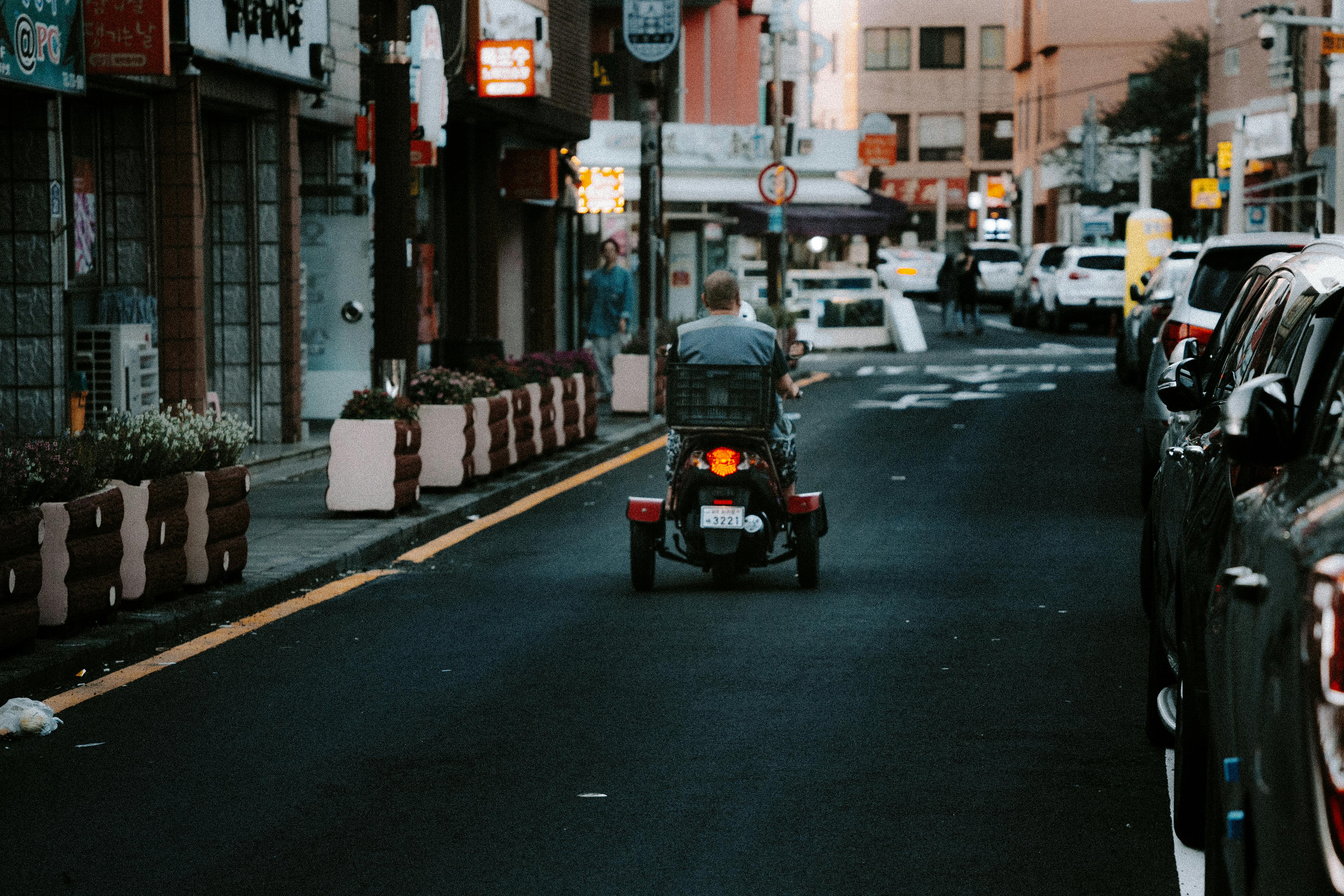 Man Riding on a Motor Scooter on a Street in City · Free Stock Photo