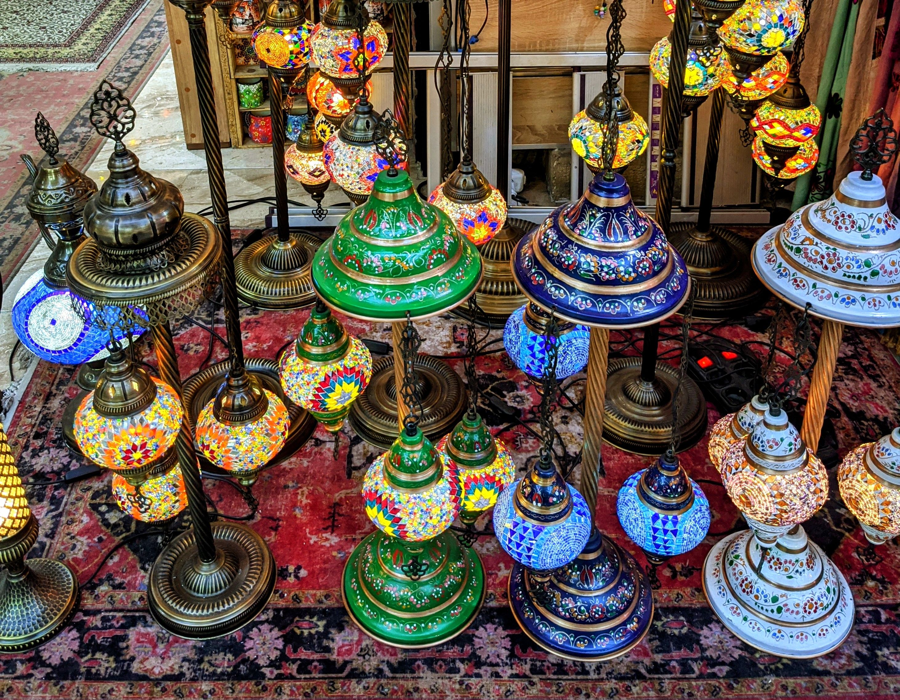 A display of colorful lamps on a rug · Free Stock Photo