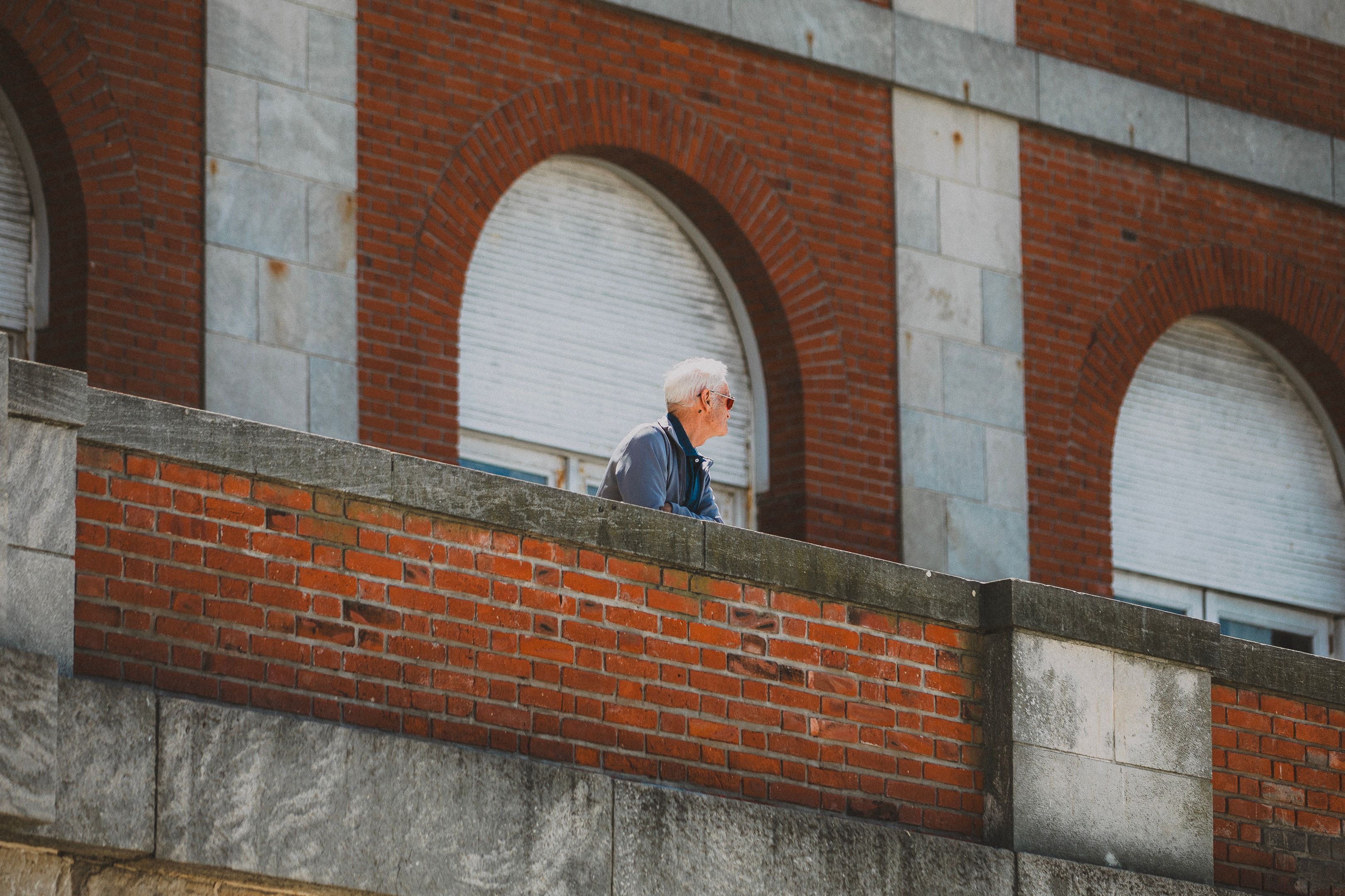 Elderly Man Standing behind Wall · Free Stock Photo