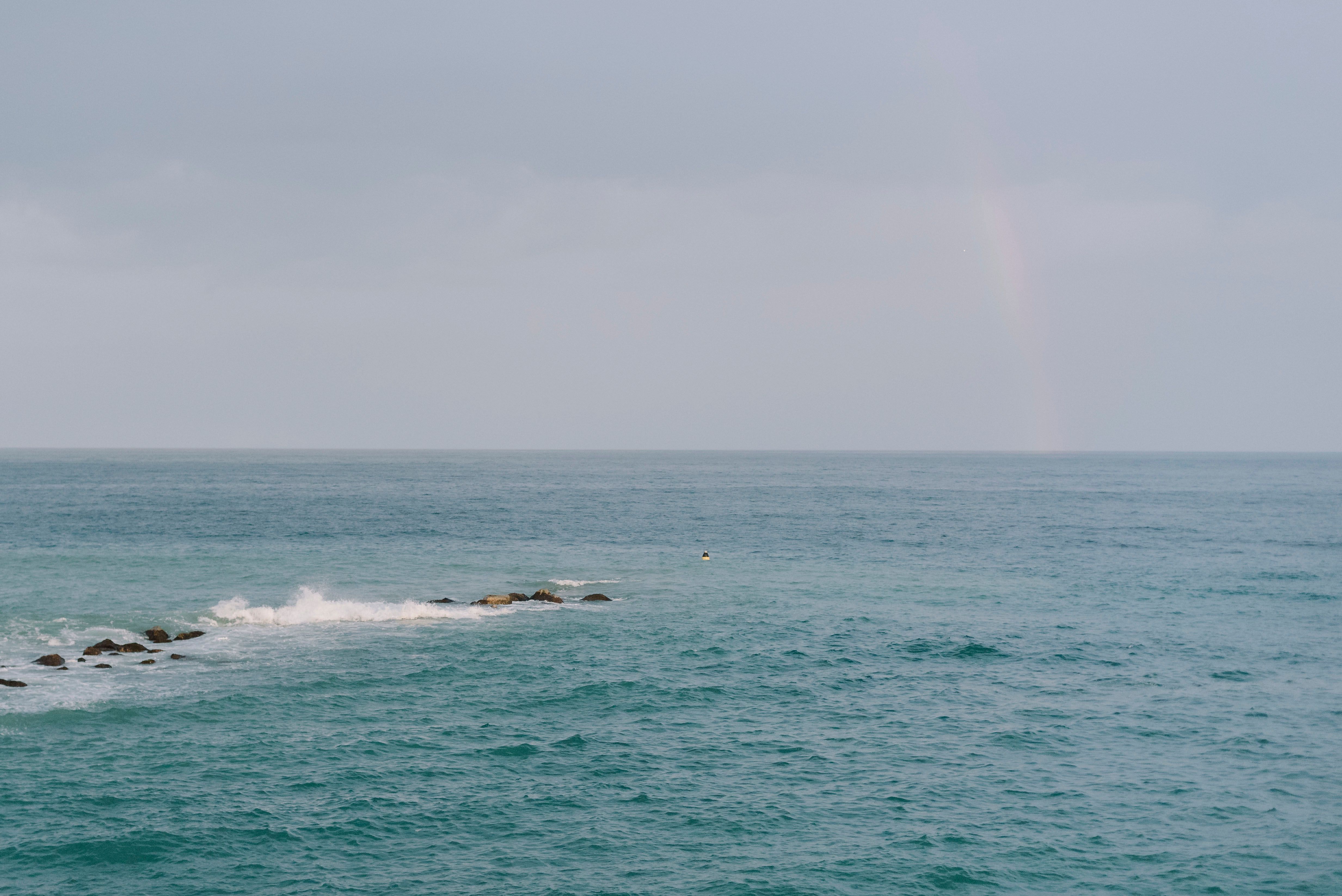 Calm Sea Coast and Rainbow behind · Free Stock Photo