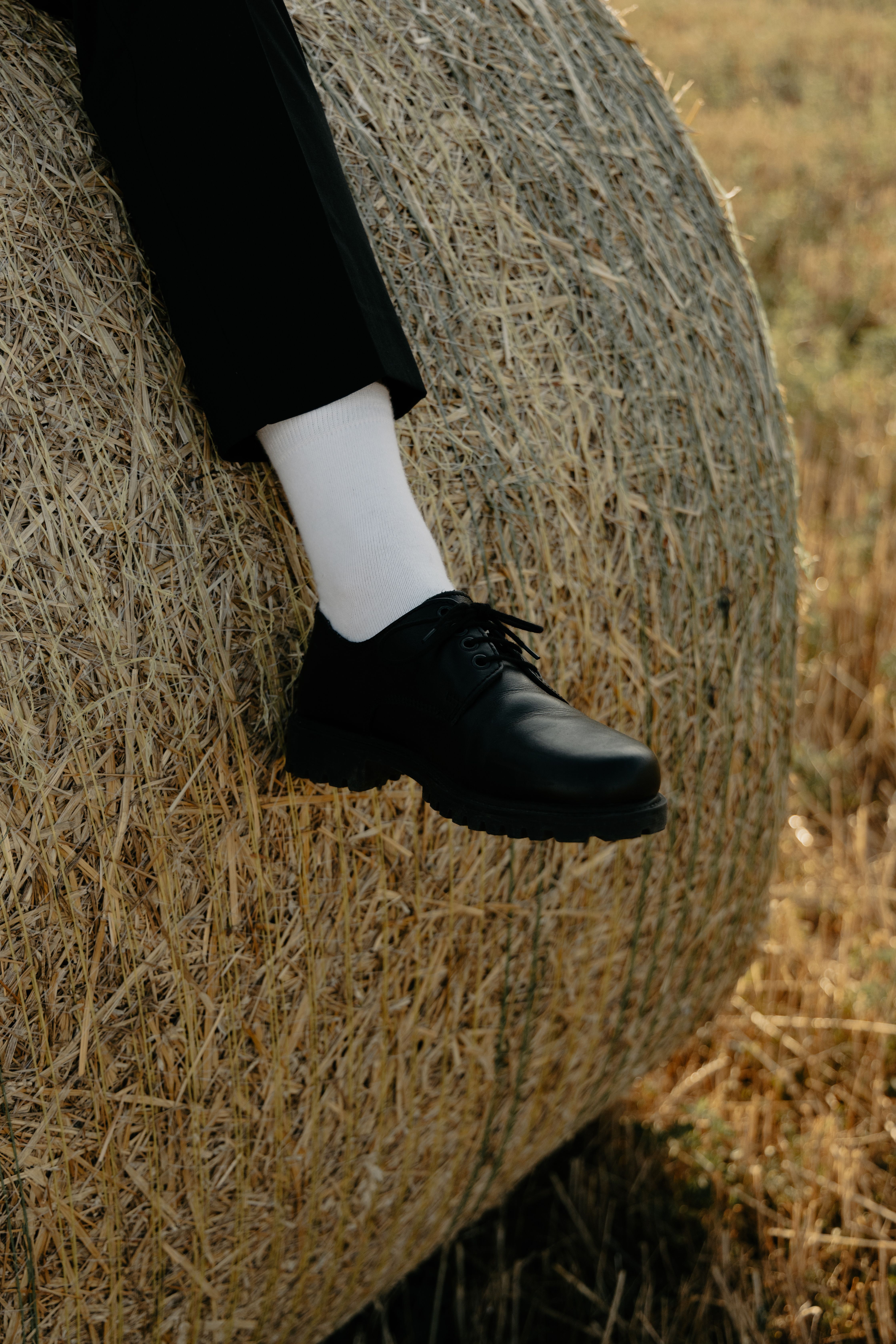 Person Sitting on a Hay Bale · Free Stock Photo