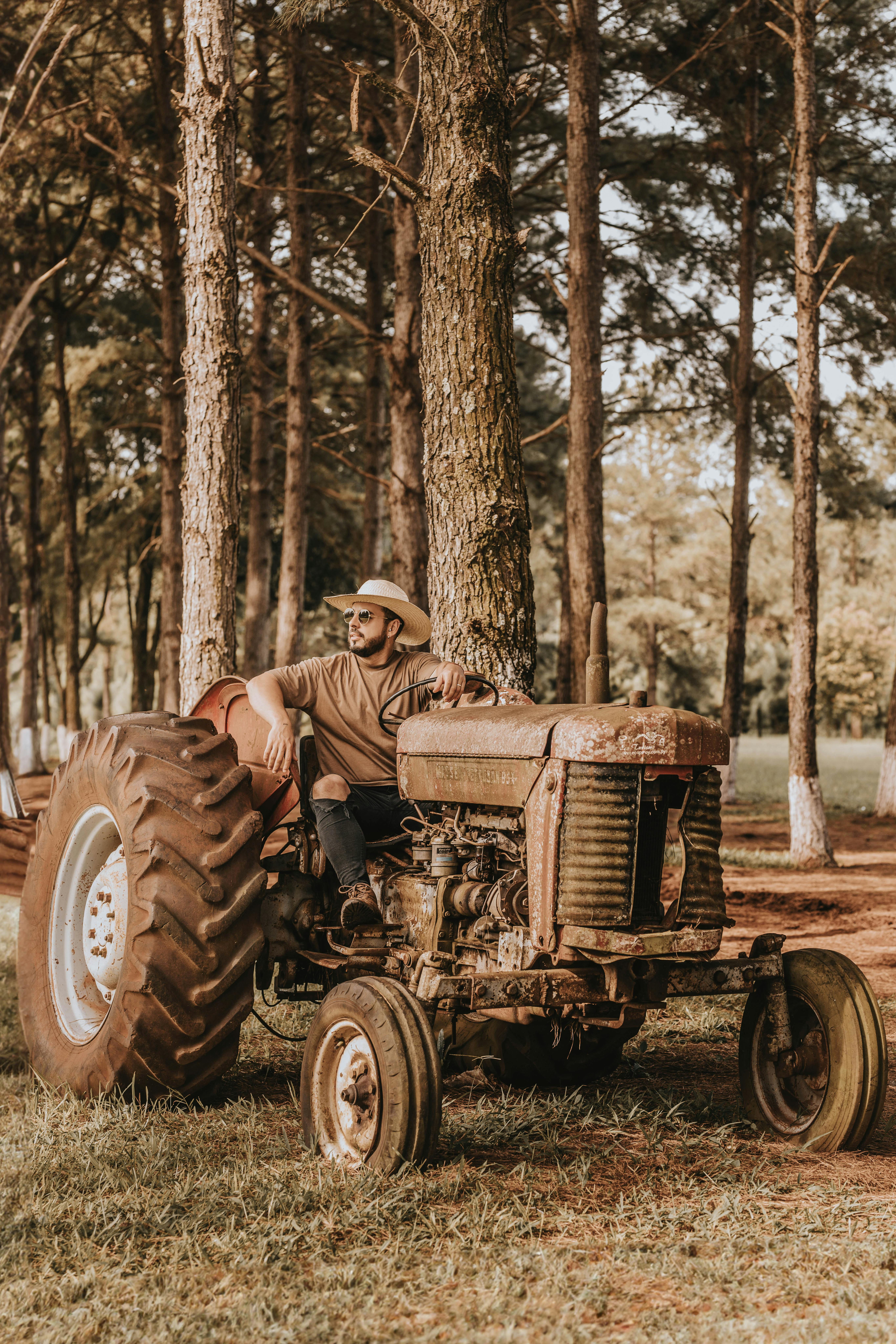 Man Sitting on Rusty Tractor · Free Stock Photo