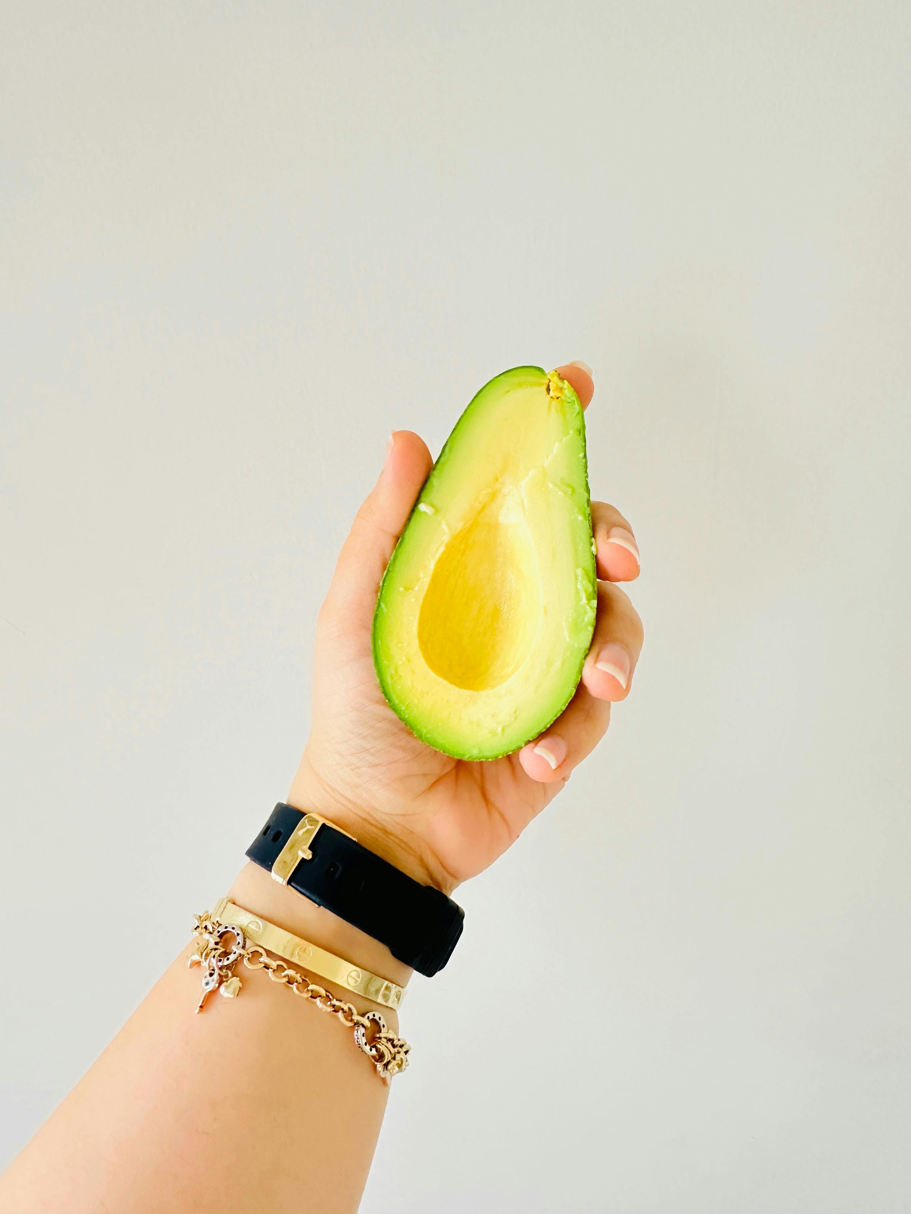 A person holding an avocado in their hand · Free Stock Photo