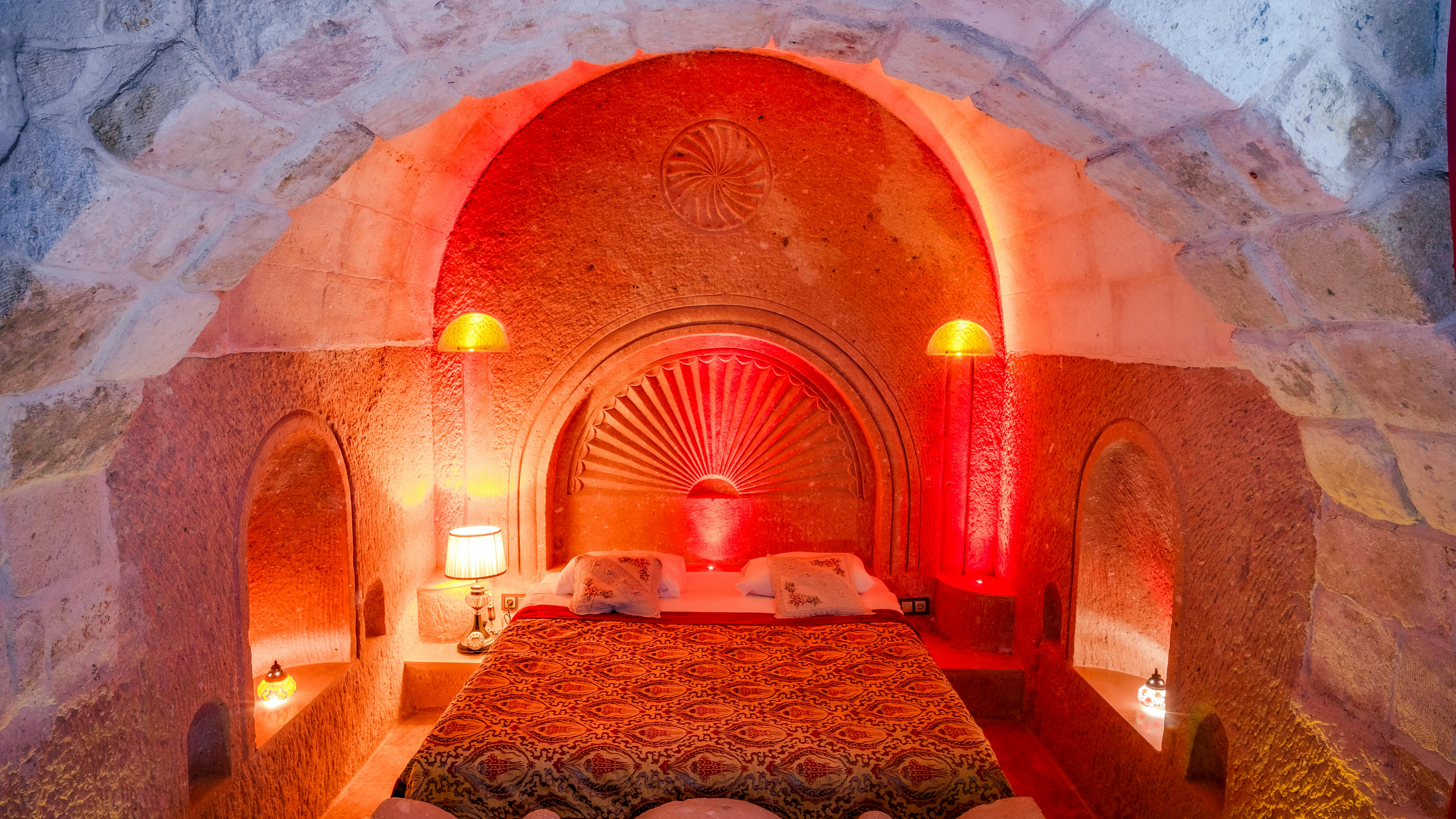 A bed in a cave with red lights · Free Stock Photo