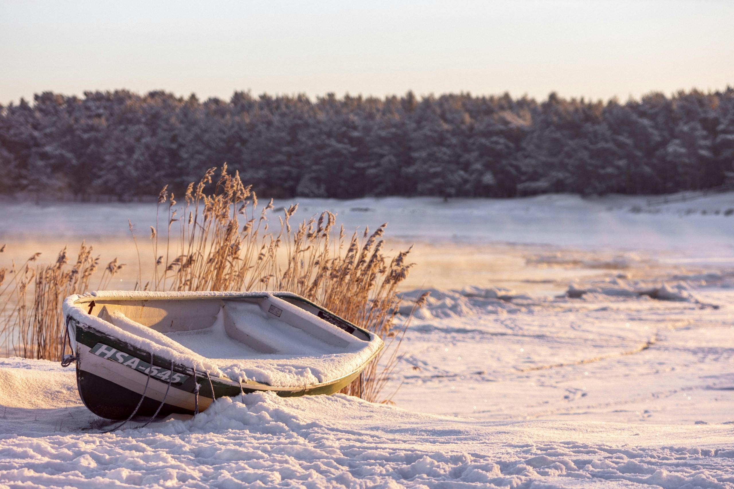 A Boat Standing on the Shore Covered in Snow · Free Stock Photo